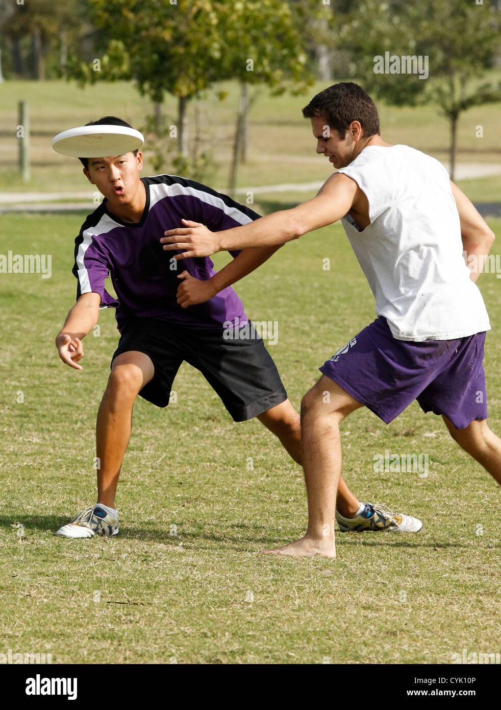 Teenage boy guards his opponent during an Ultimate frisbee game at a ...