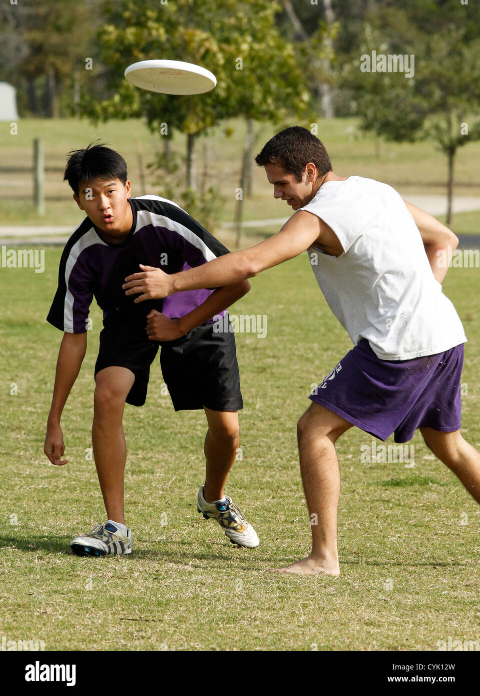 Teenage boy guards his opponent during an Ultimate Frisbee game at a ...