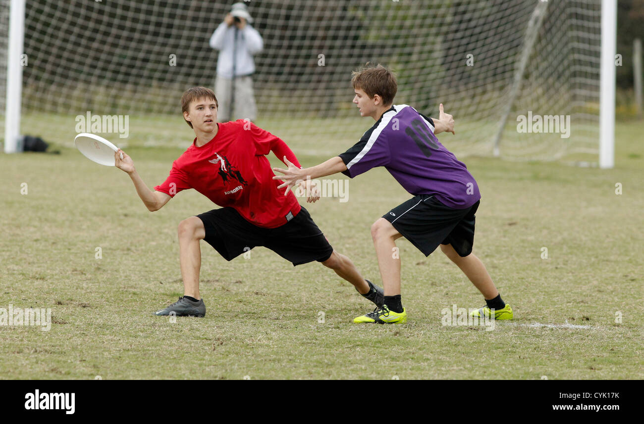 Teenage boy guards his opponent during an Ultimate Frisbee game at a ...