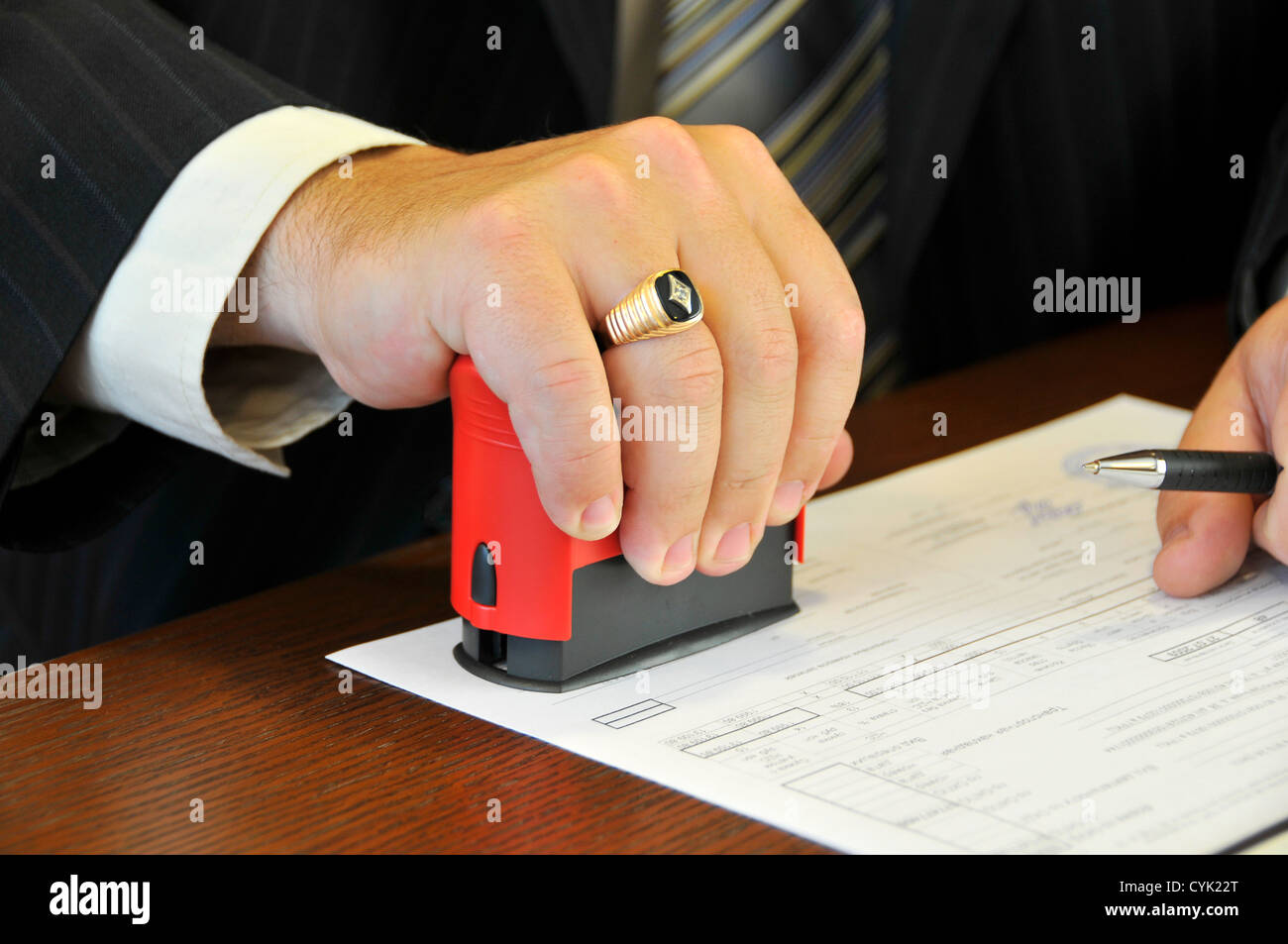 Man is putting stamp on a business papers Stock Photo - Alamy