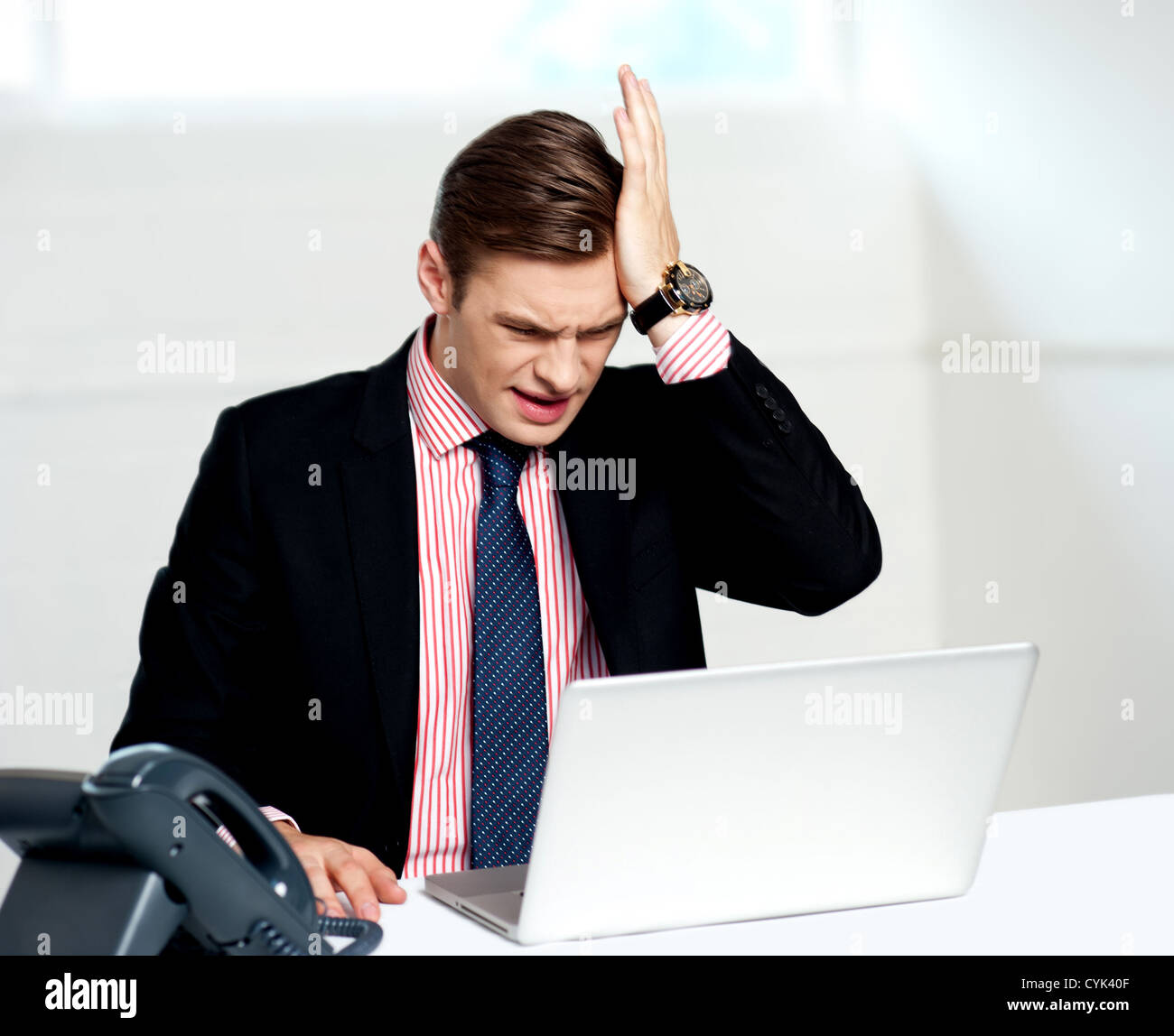 Unhappy businessperson looking at his laptop. Business loss Stock Photo ...