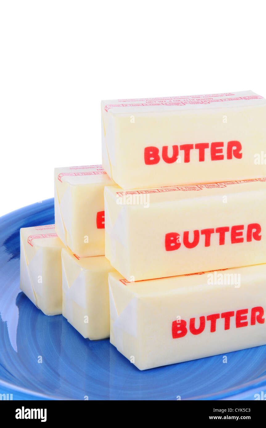 Closeup of sticks of wrapped butter on a blue plate. Vertical format ...