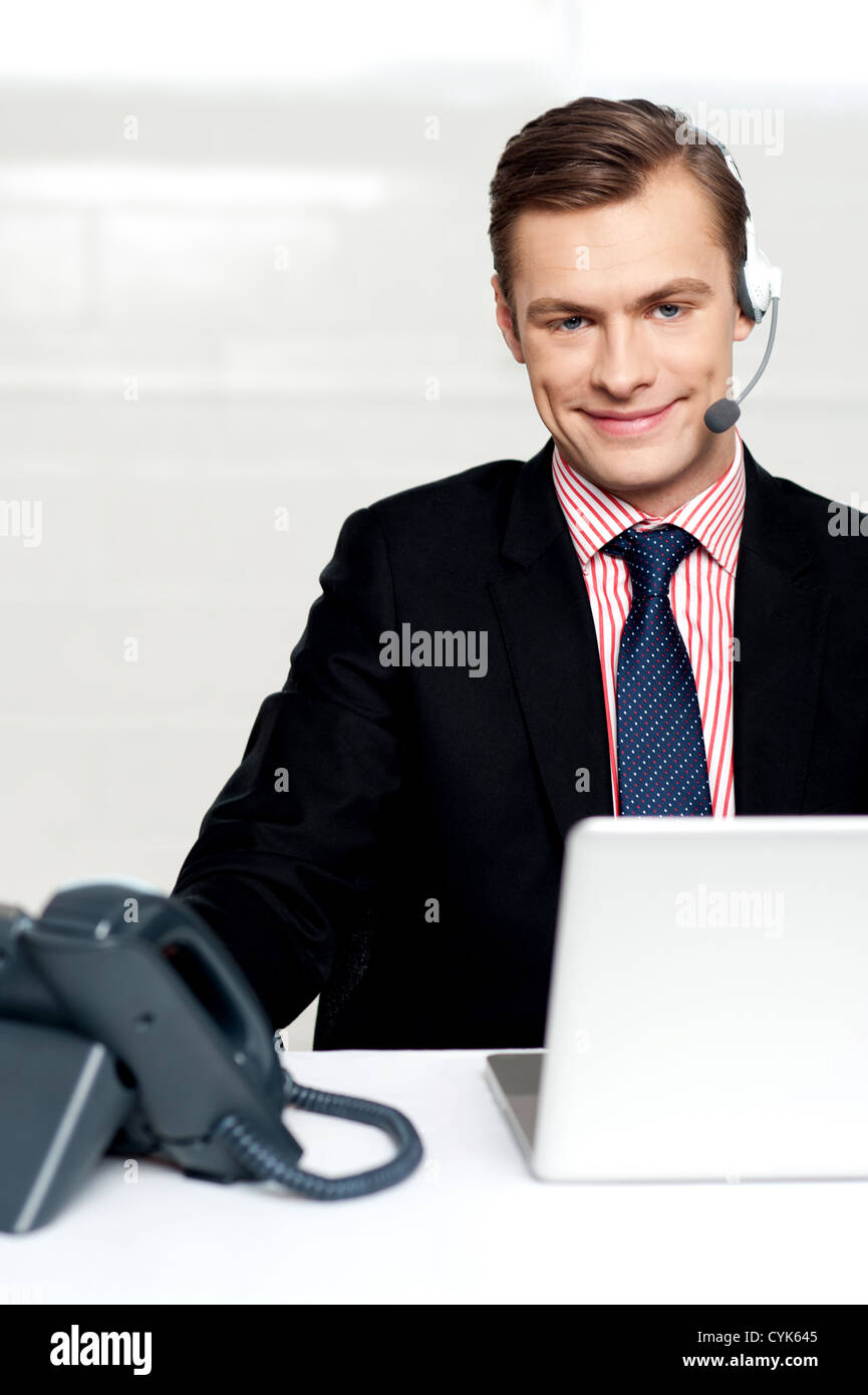 Male executive wearing headsets and smiling. Sitting in office Stock ...