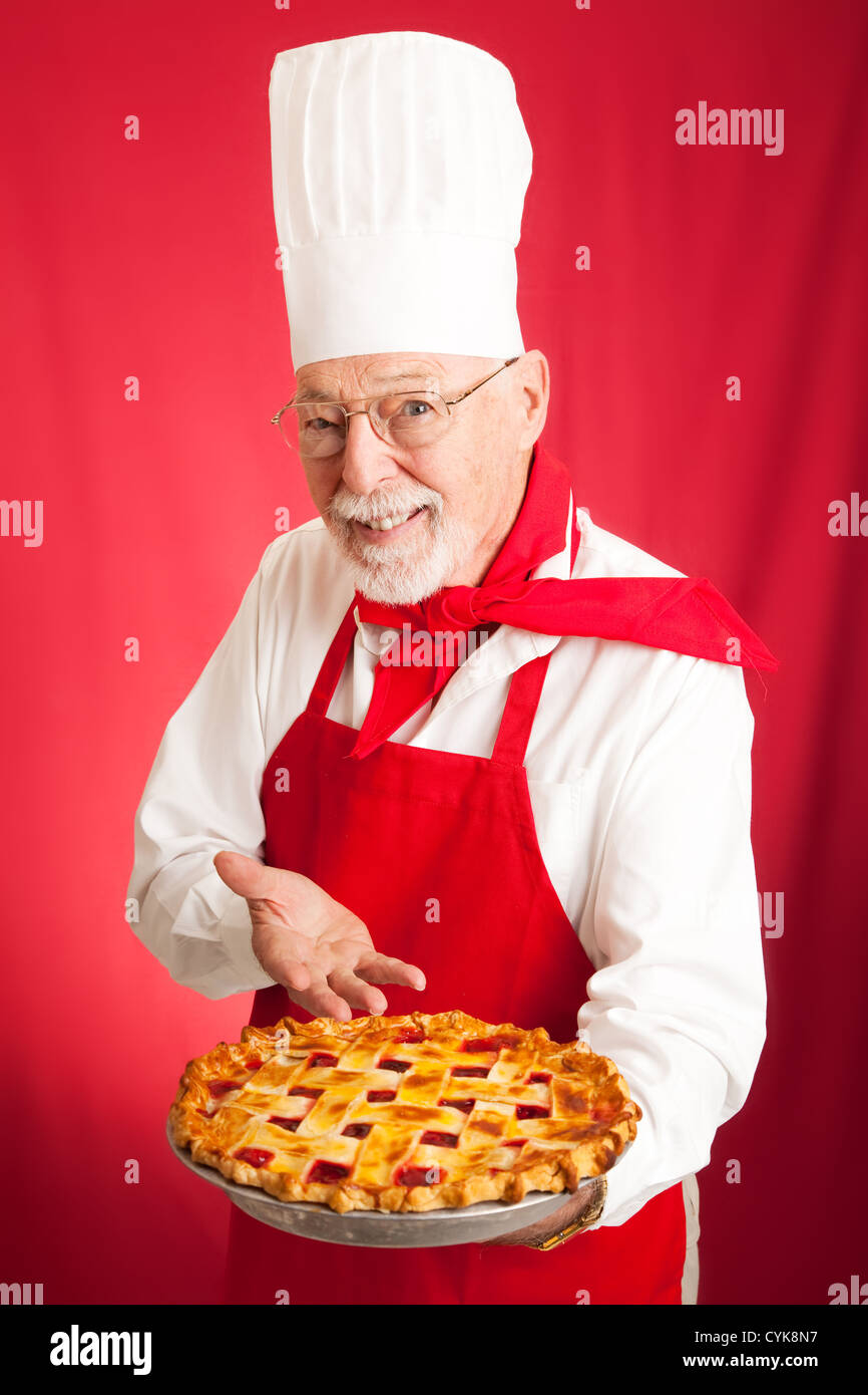 Chef holding a fresh baked cherry pie over a red background Stock Photo ...