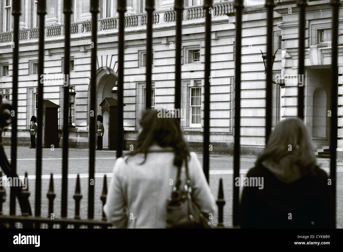 People looking through railings at Buckingham Palace Stock Photo - Alamy
