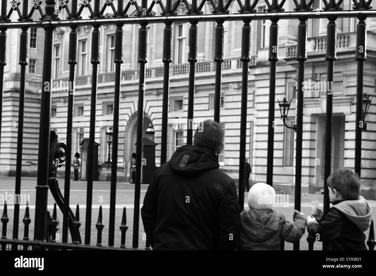 People looking through railings at Buckingham Palace Stock Photo - Alamy