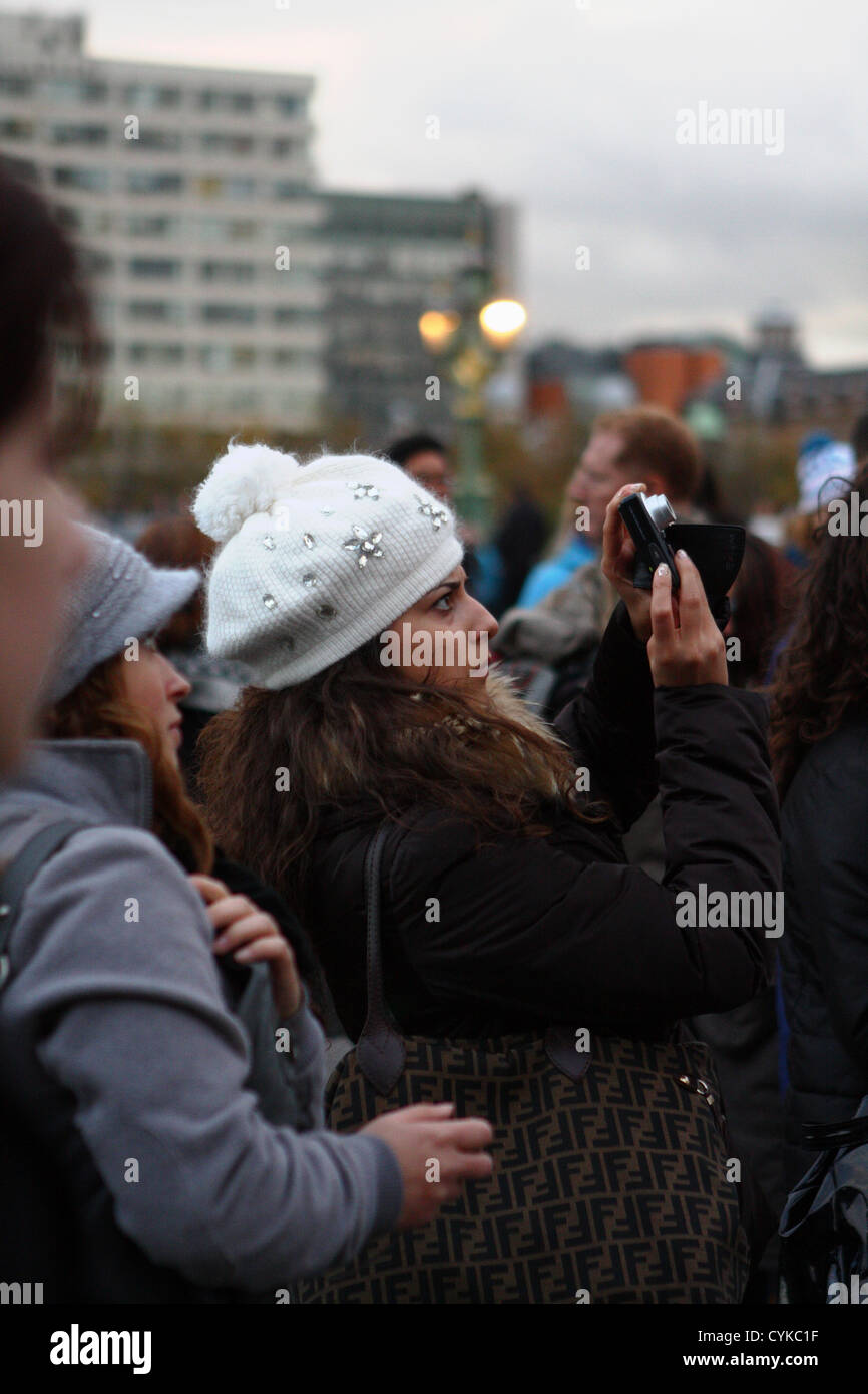A girl taking a photo in a crowd of people Stock Photo - Alamy