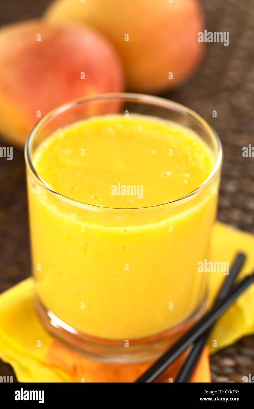 Fresh homemade mango juice in glass with straws on the side and mango ...