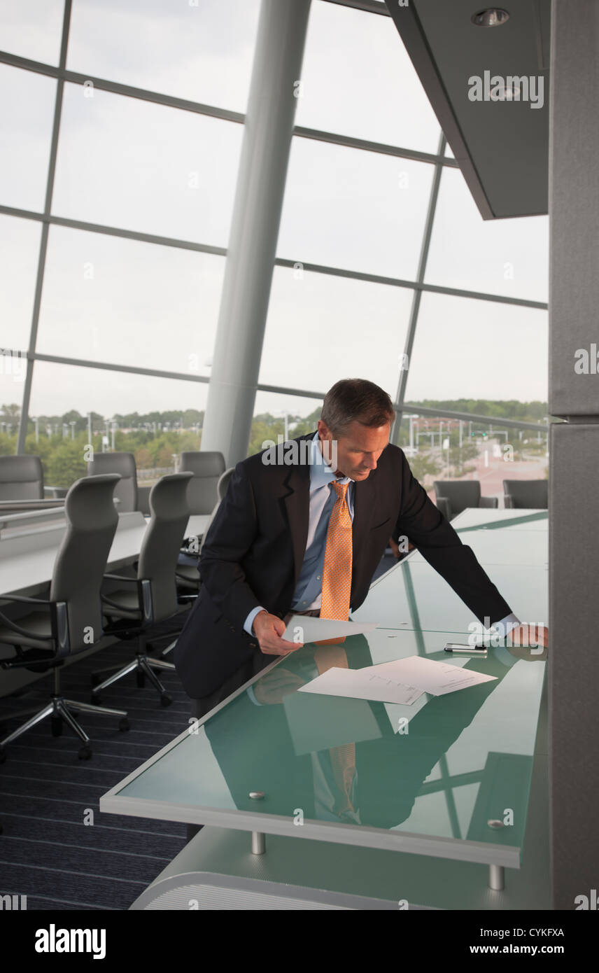 Caucasian businessman looking at paperwork in conference room Stock ...