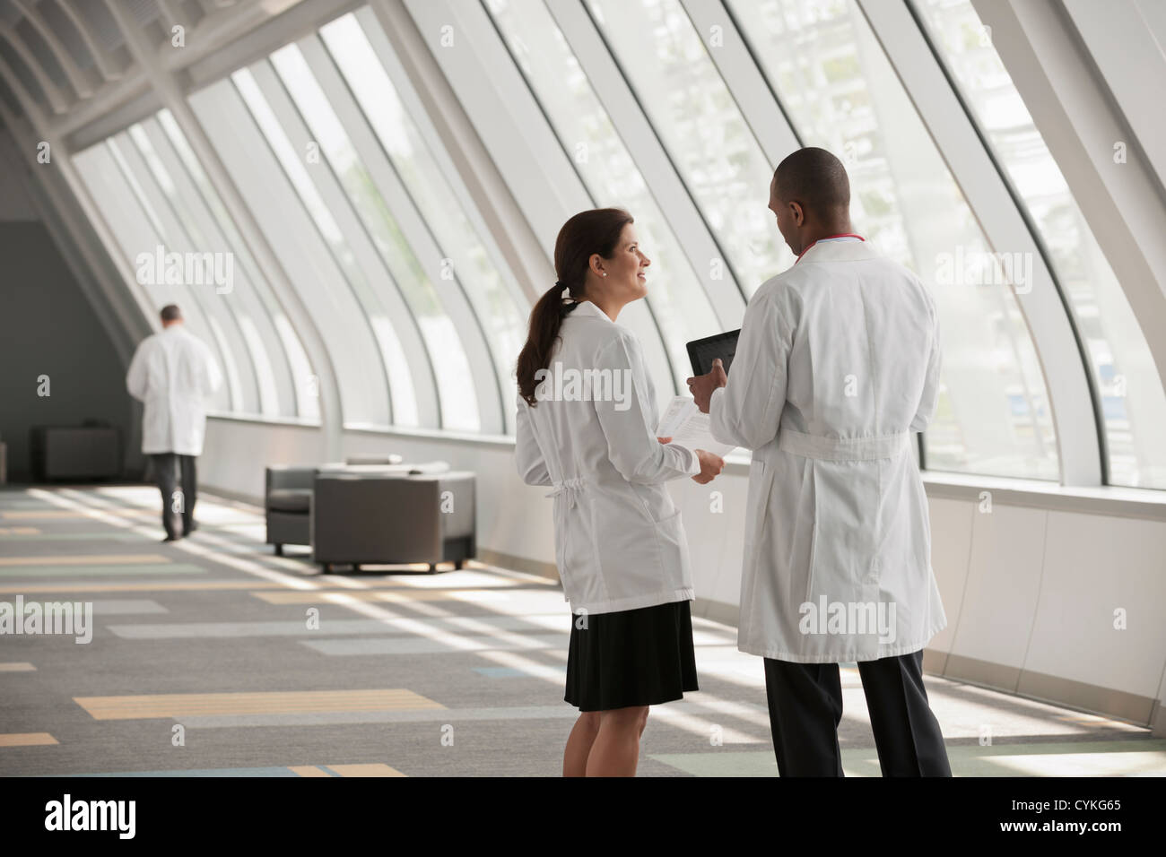 Doctors talking together in hospital corridor Stock Photo - Alamy