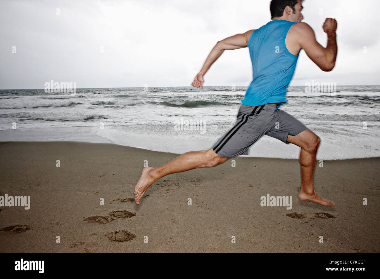 Young man running on beach black hi-res stock photography and images ...