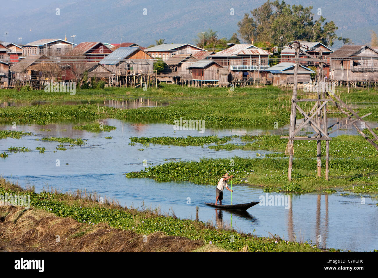 Myanmar, Burma. Burmese Man Paddles his Canoe through Village Waterway ...