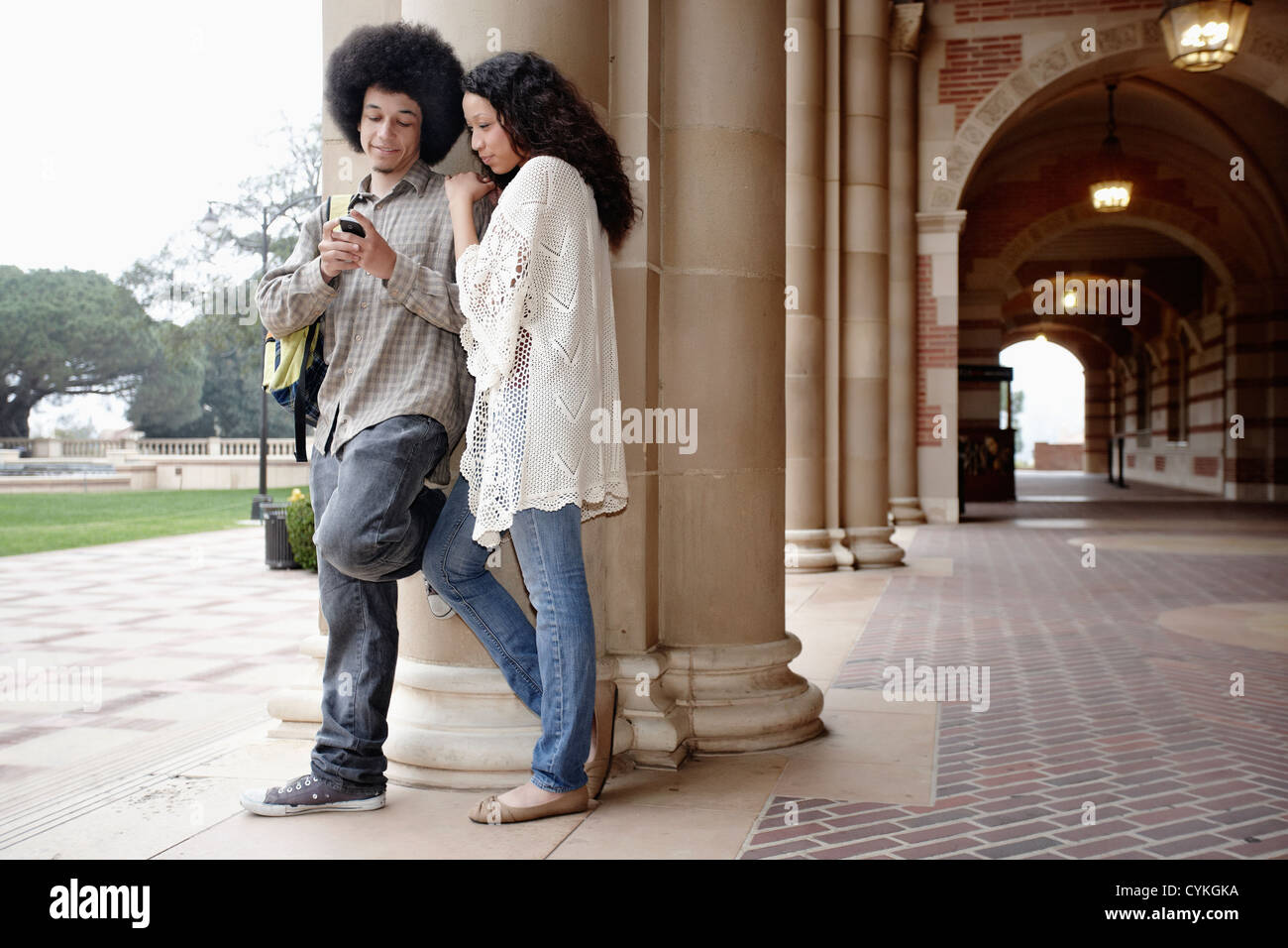 Students looking at cell phone together Stock Photo - Alamy