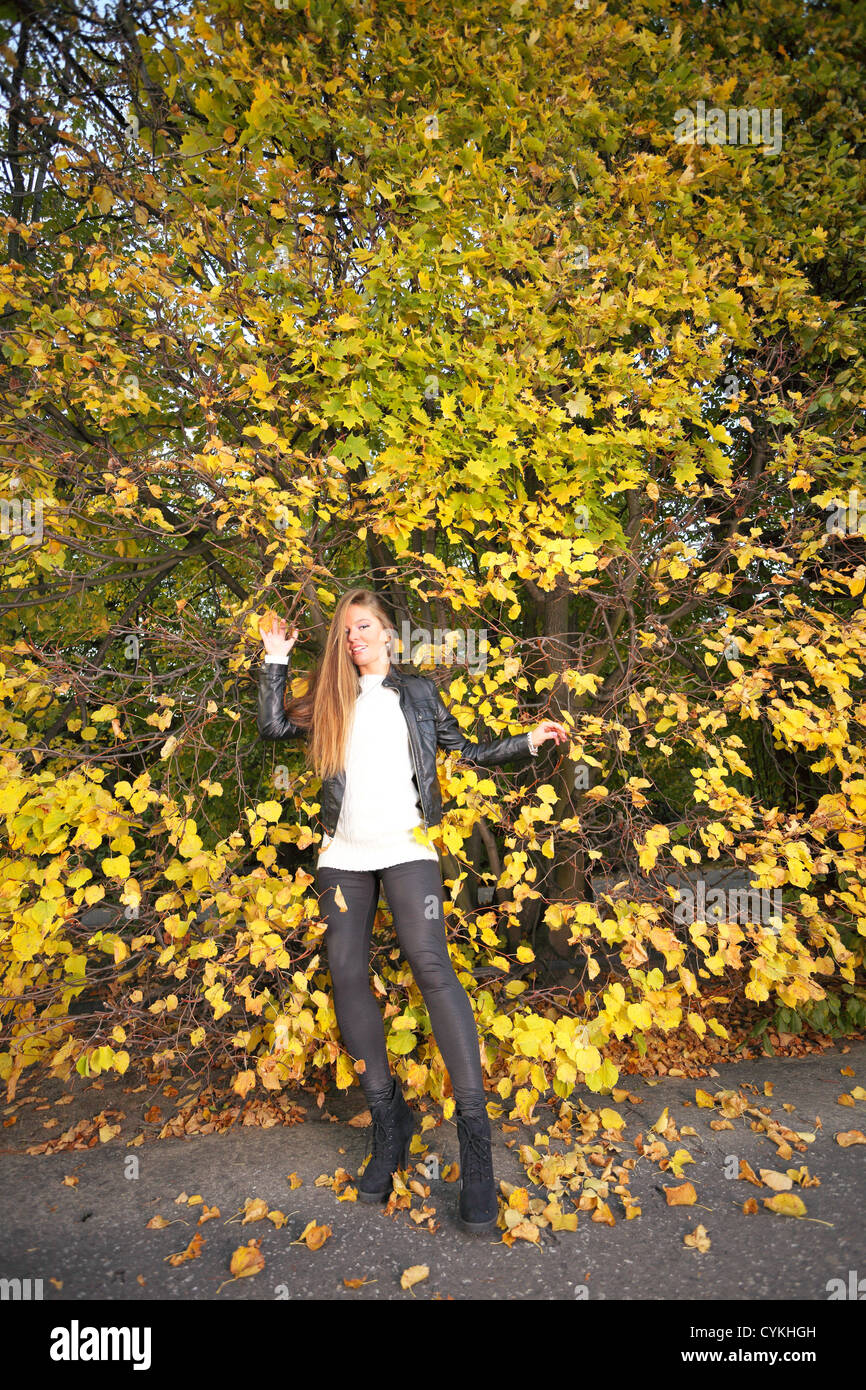 Young woman stand autumn leaves fall yellow green girl garden ...