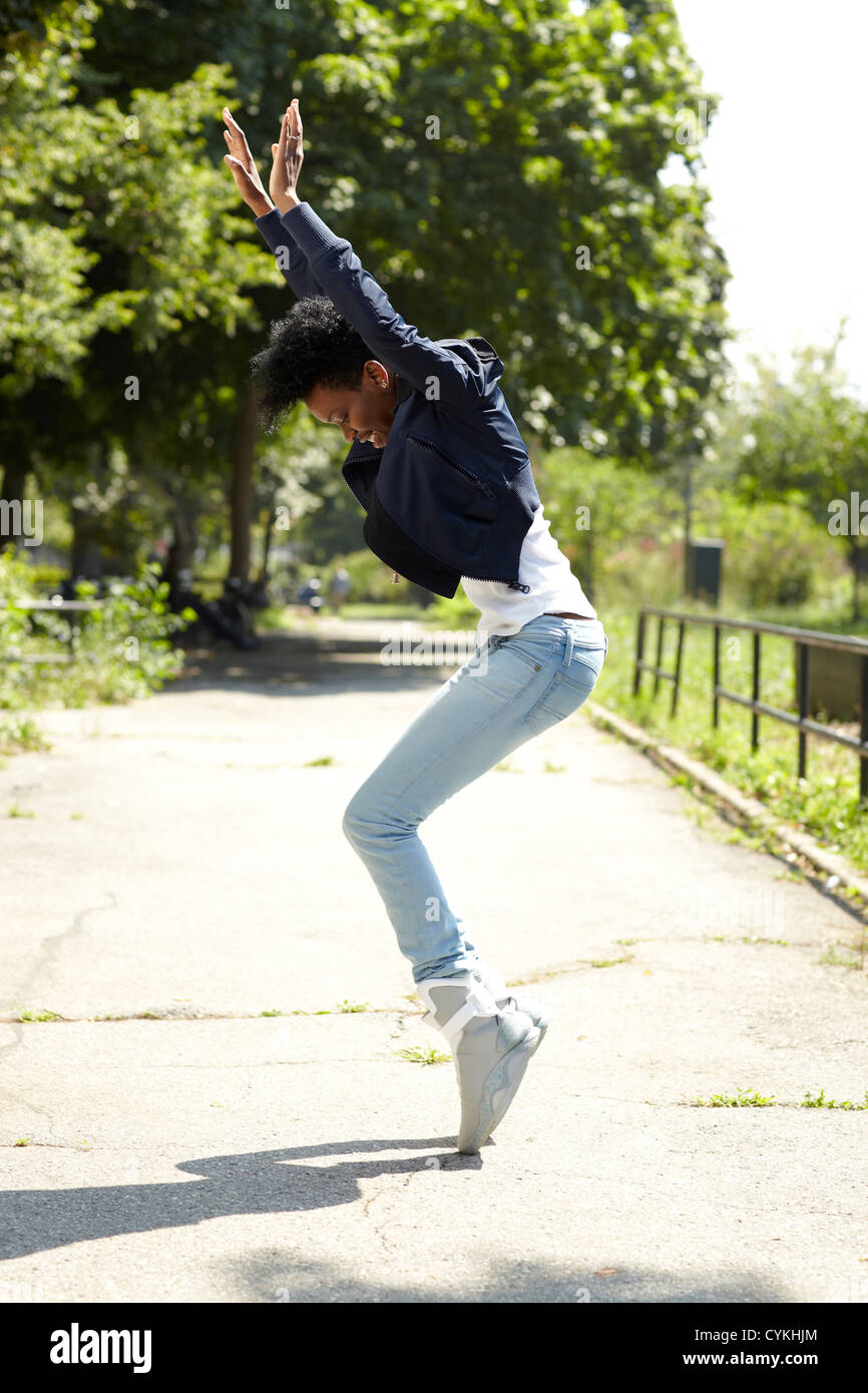 Black woman balancing on toes in park Stock Photo - Alamy