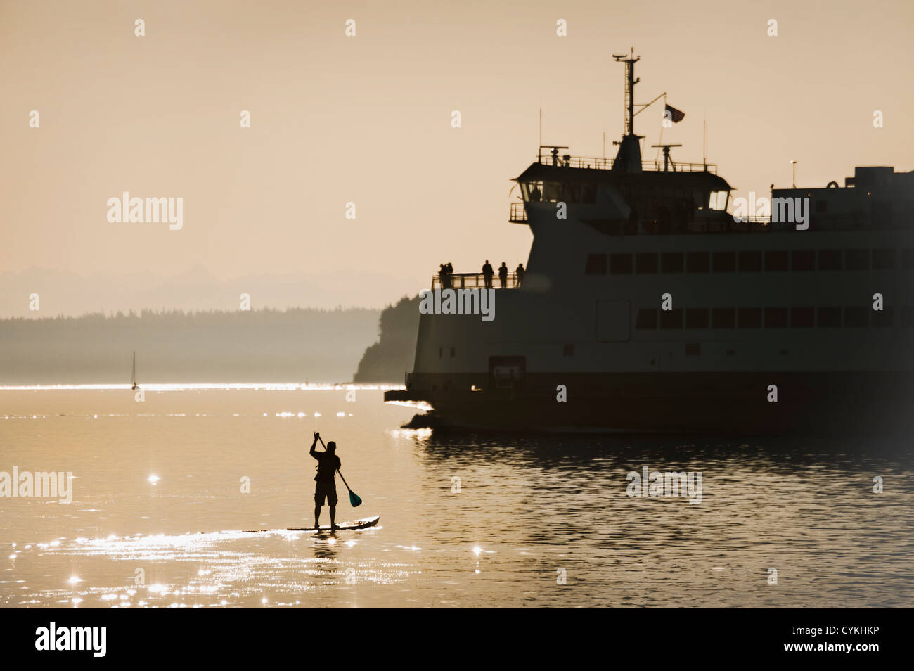 A paddleboarder heads towards a Washington State Ferry in the Puget ...
