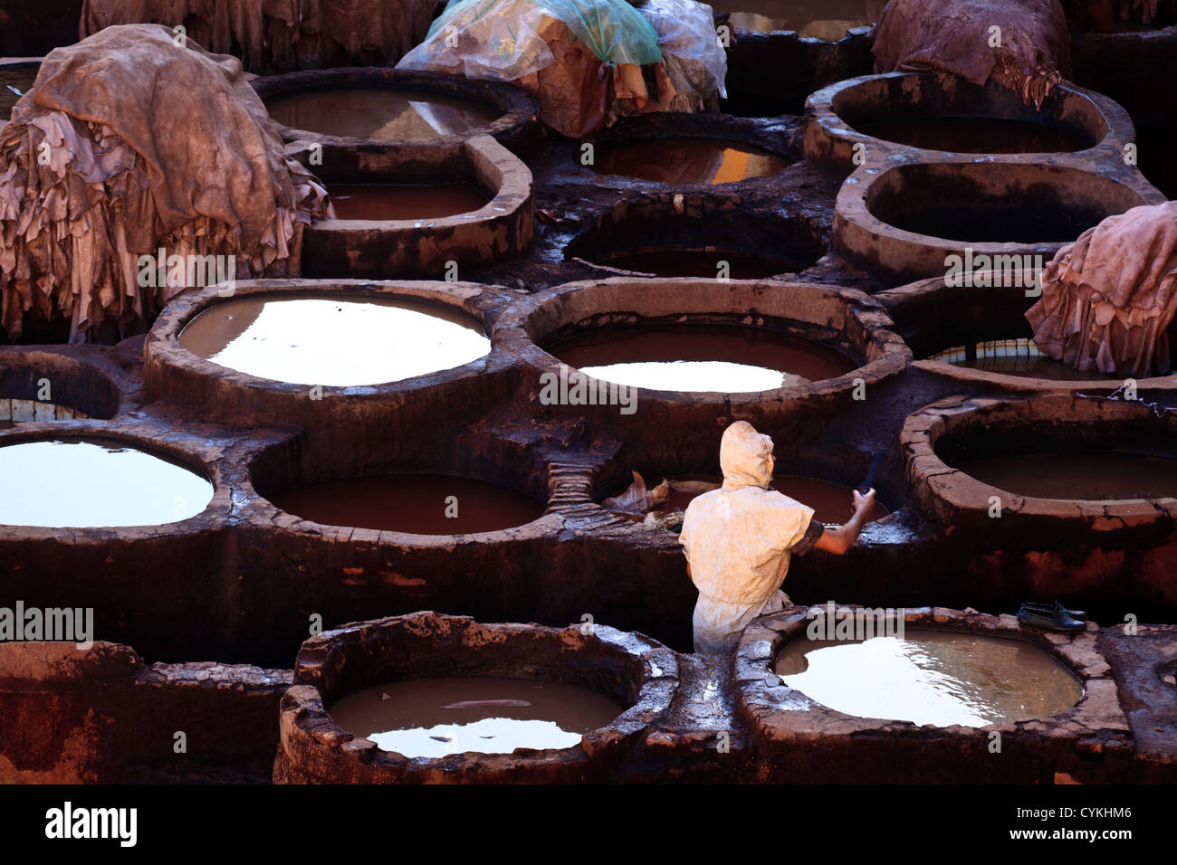 Tanning pools and worker at a traditional leather tannery in Fez ...
