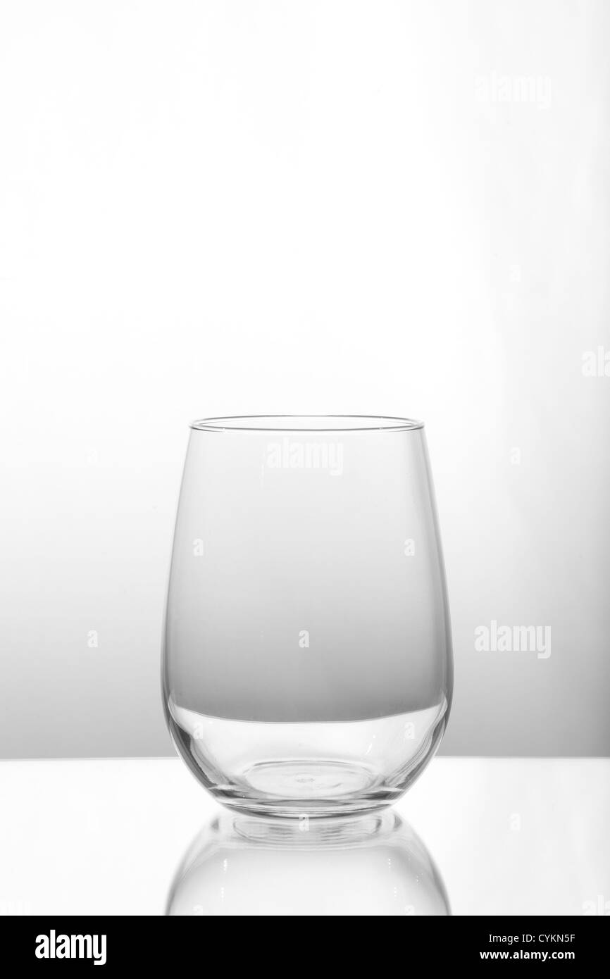 A clear, glass cup against a white background Stock Photo - Alamy