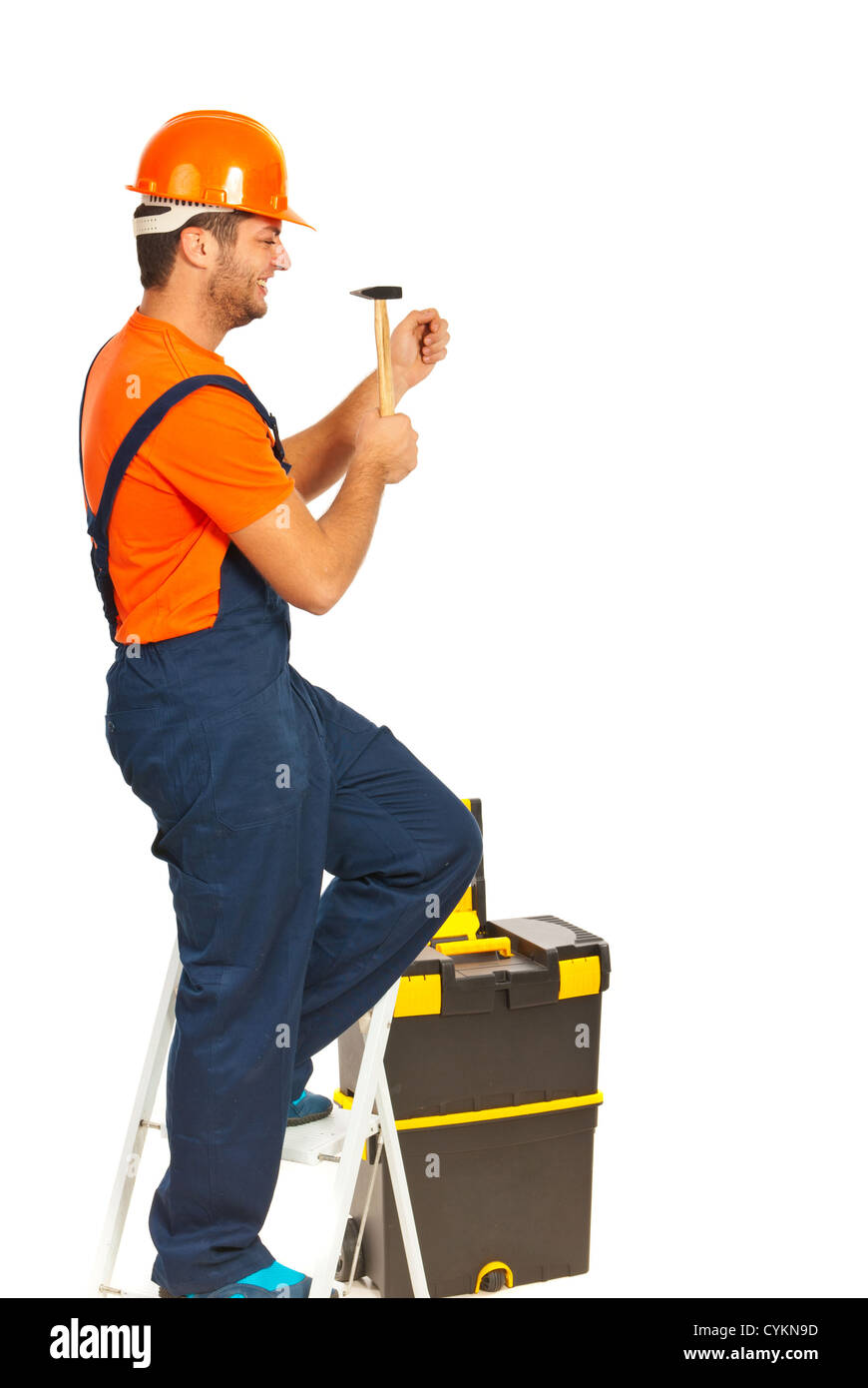 Builder man standing on step ladder and working with a hammer isolated ...