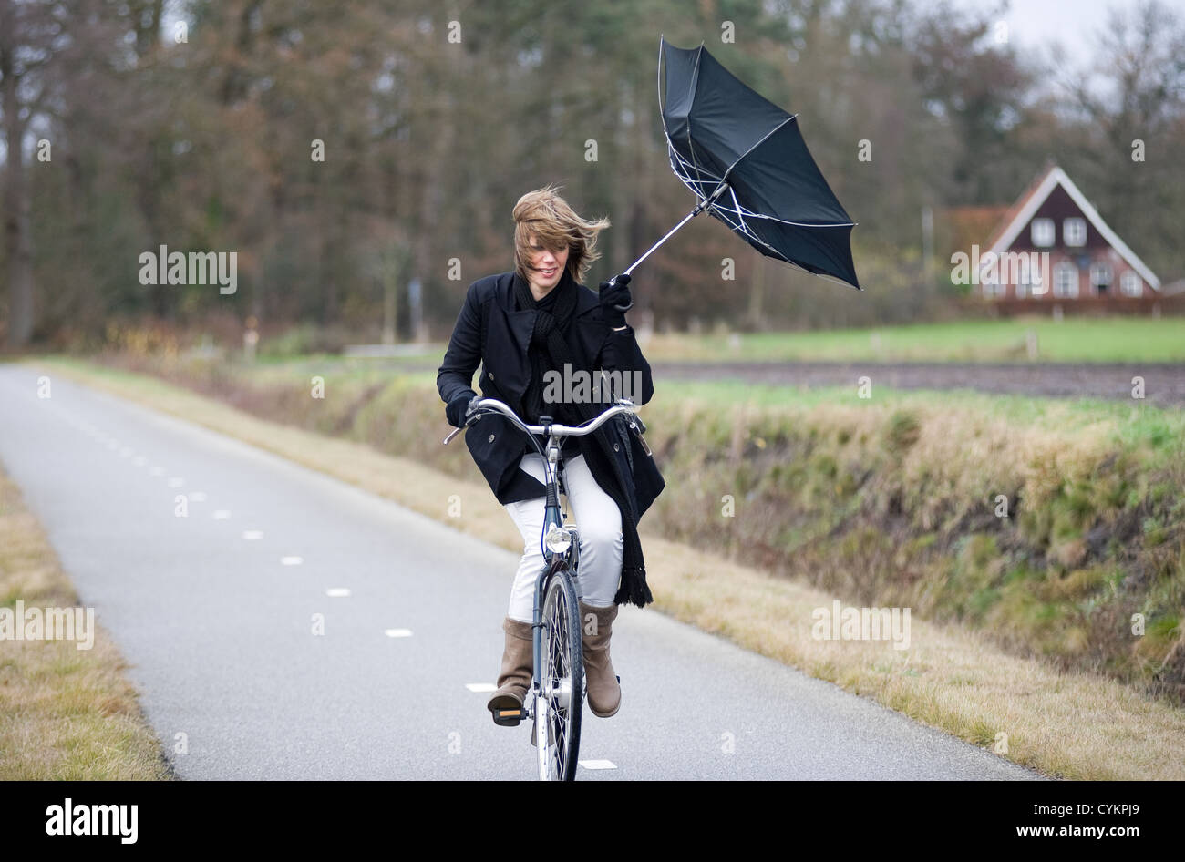 A young woman is fighting against the storm with her umbrella Stock ...