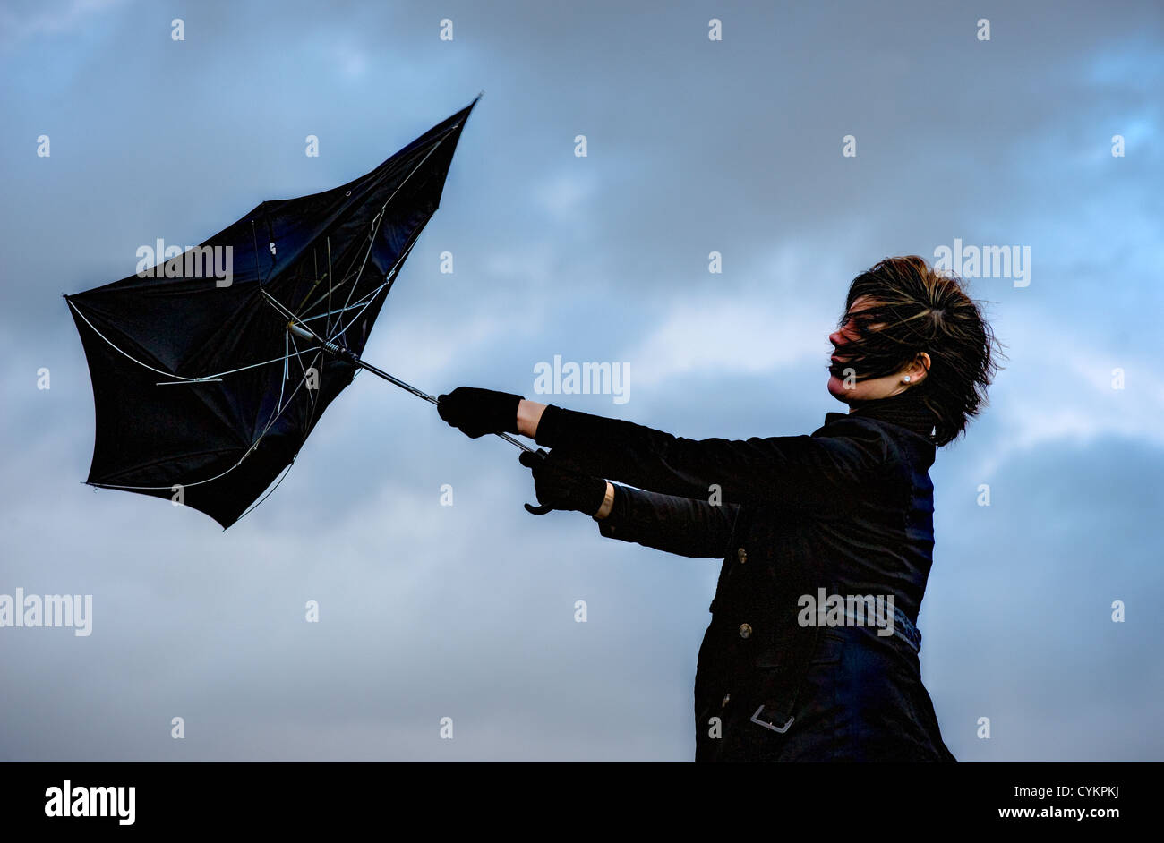 A young woman is fighting against the storm with her umbrella Stock ...