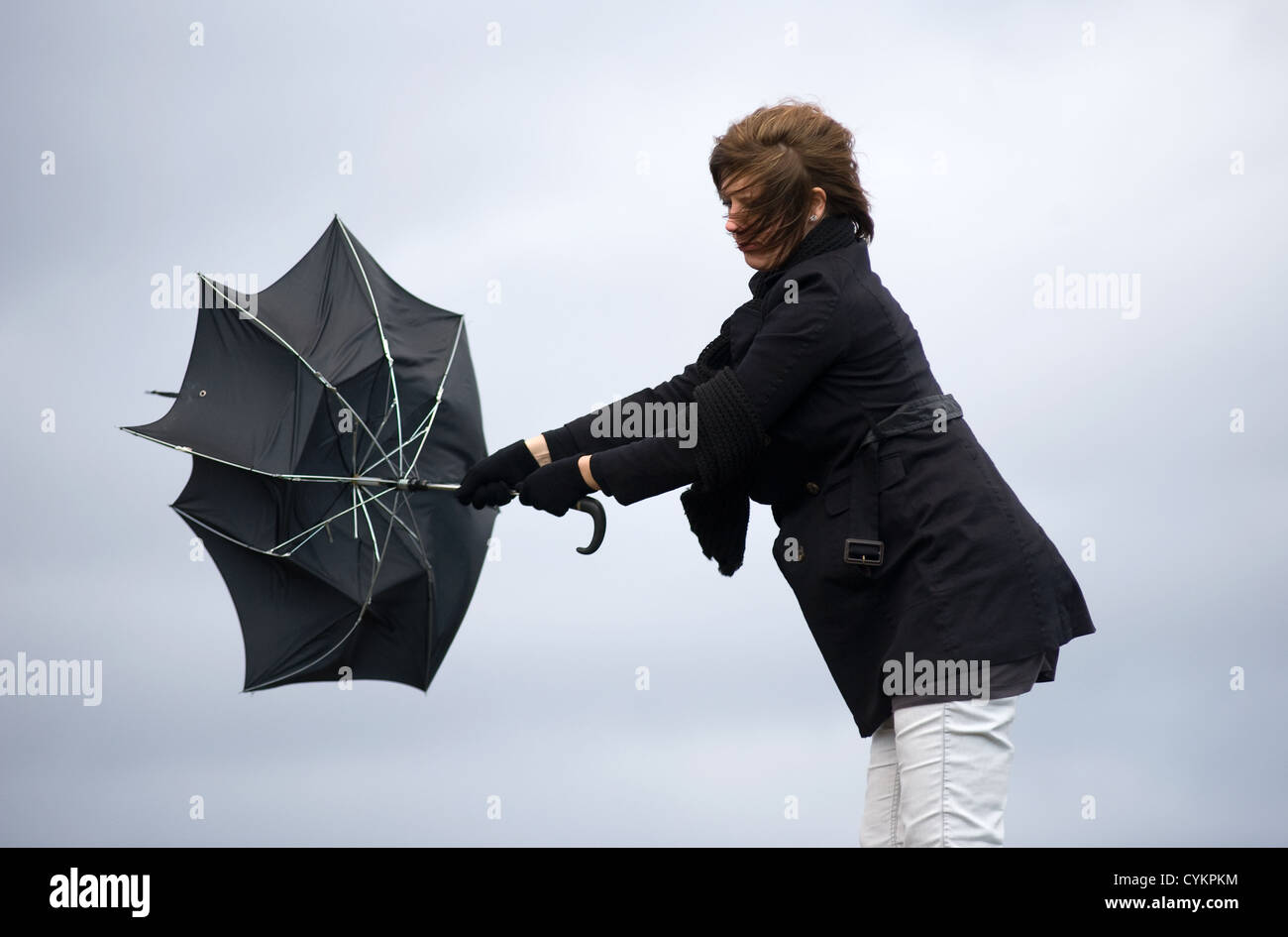 A young woman is fighting against the storm with her umbrella Stock ...