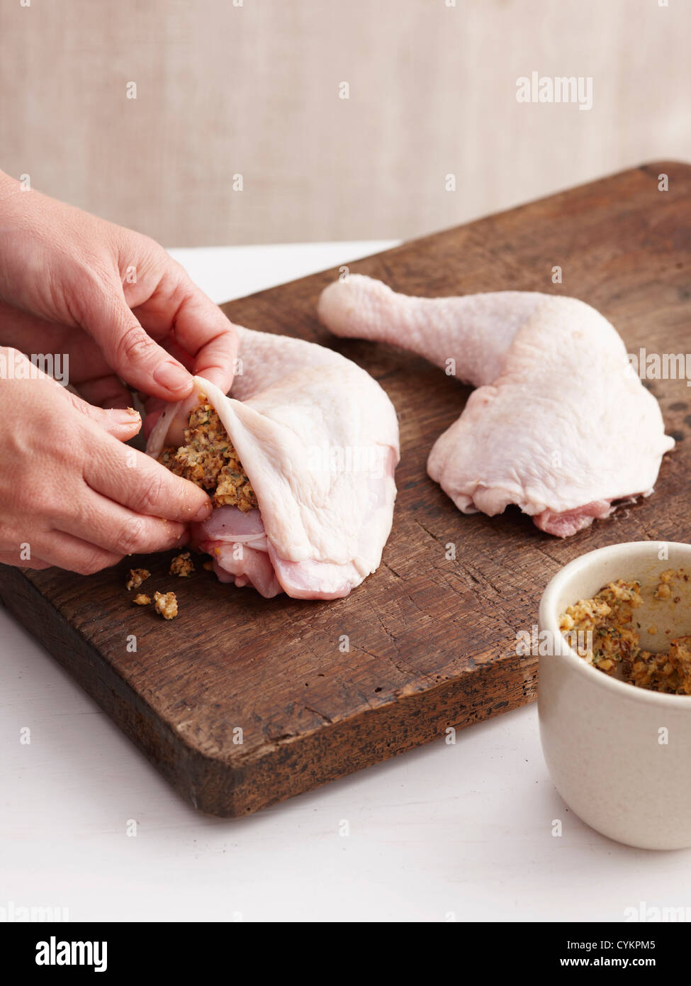 Hands stuffing chicken legs Stock Photo - Alamy