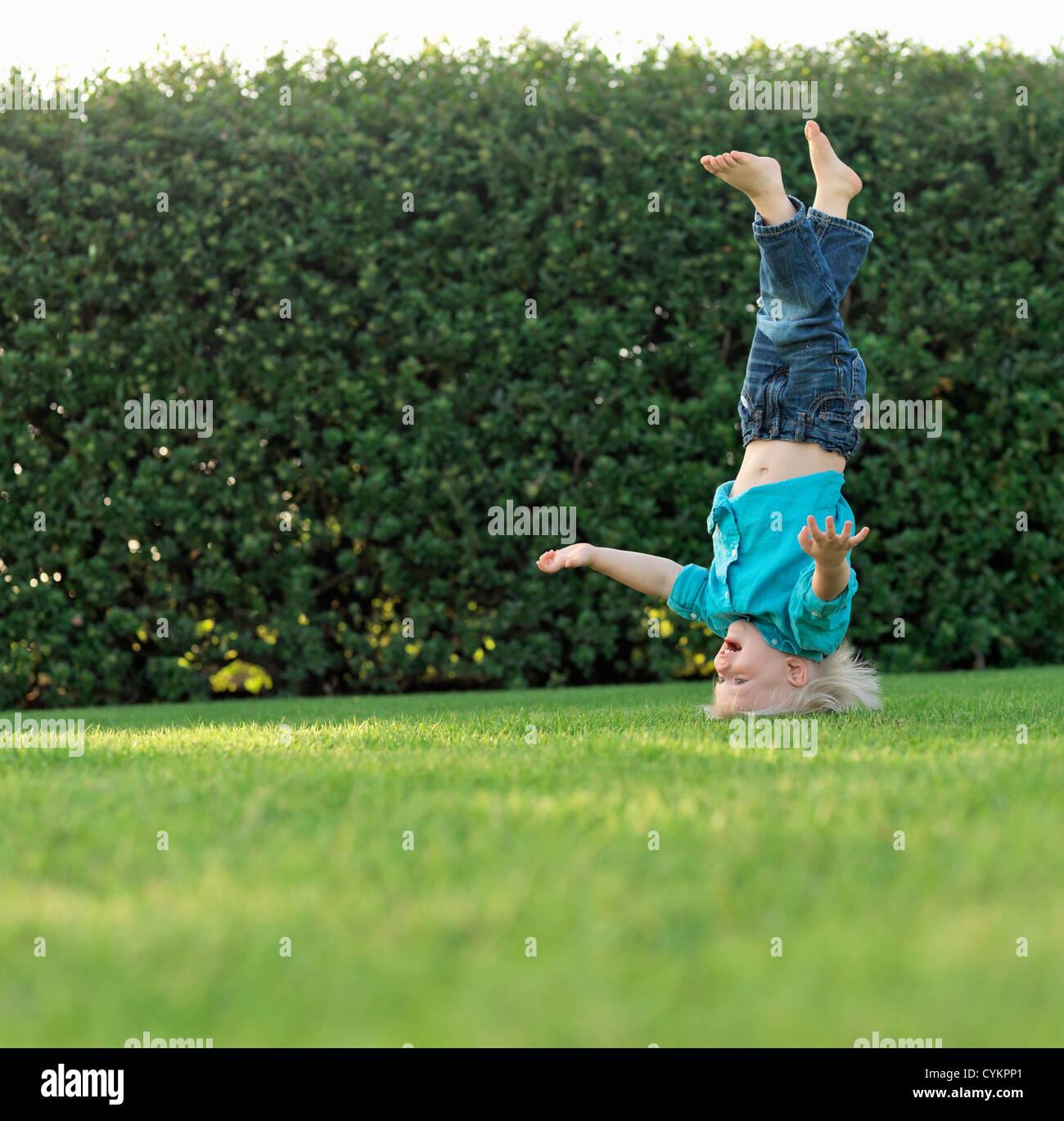 Boy balancing on his head in backyard Stock Photo - Alamy