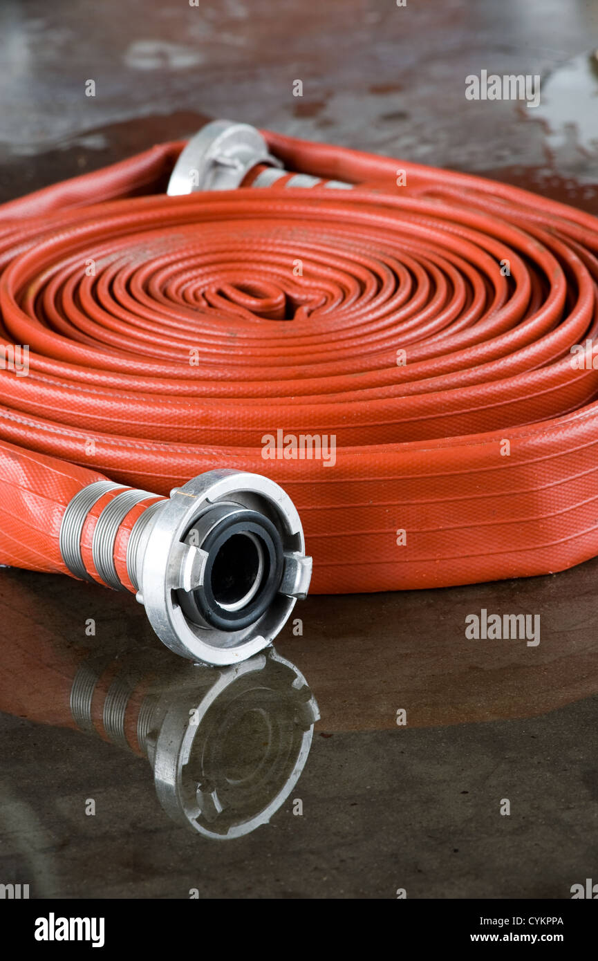 A rolled up firehose on the wet floor in a firestation used by ...