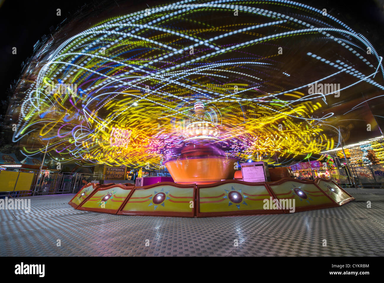 A night time swirl of colorful light trails from the amusement rides at ...