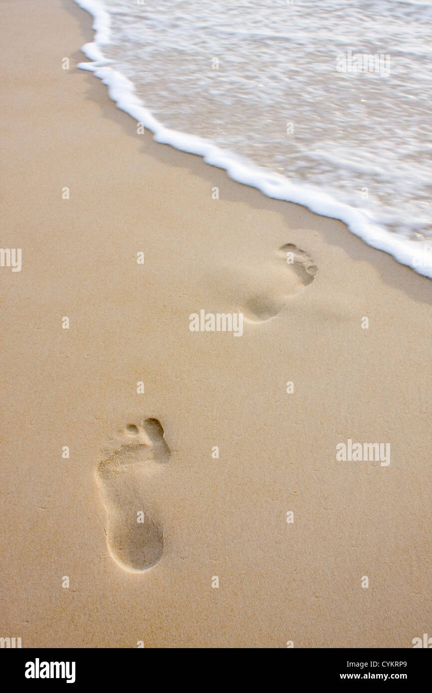 Two footprints on a beach leading into the sea Stock Photo - Alamy