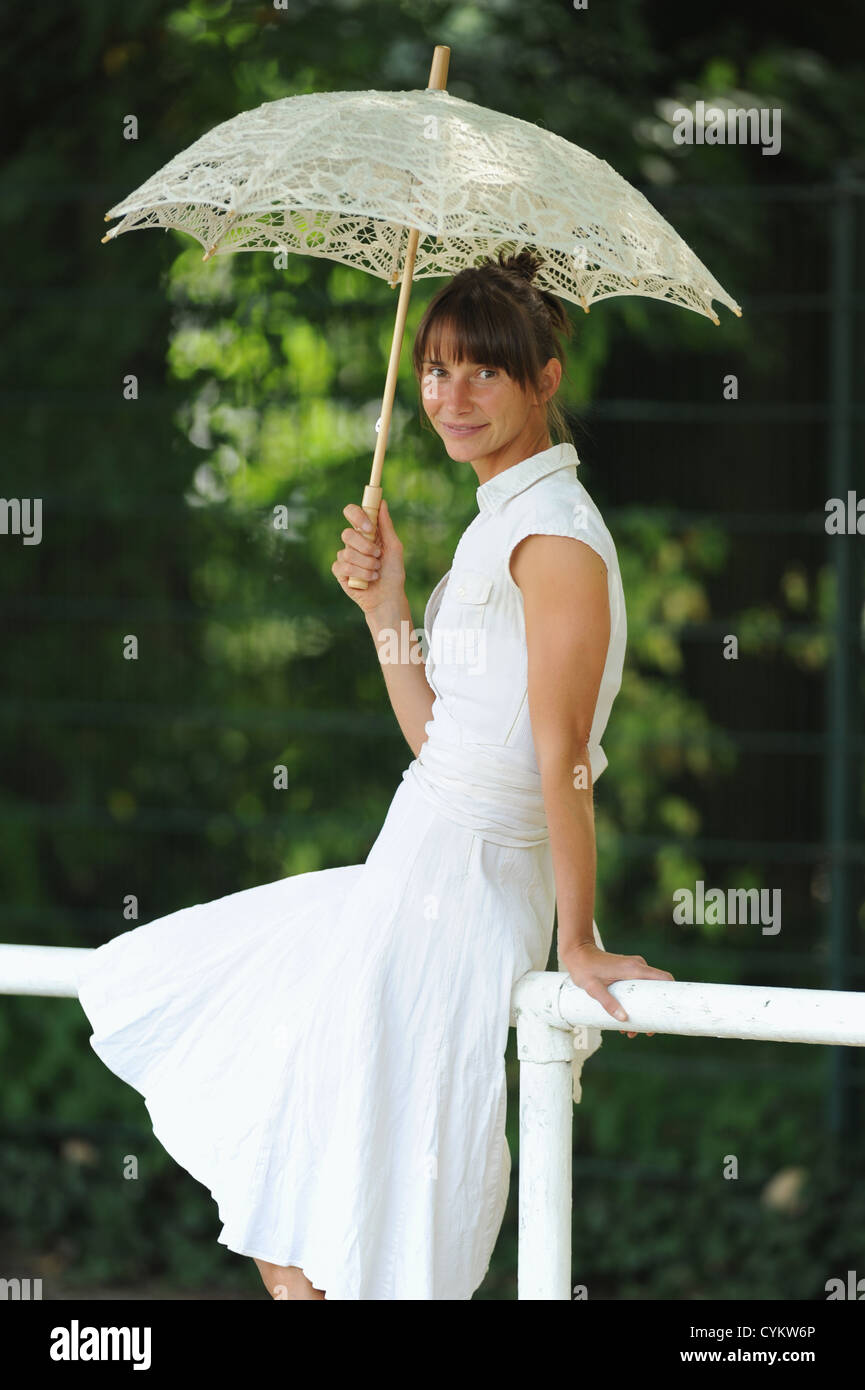 Woman sitting on railing outdoors Stock Photo - Alamy