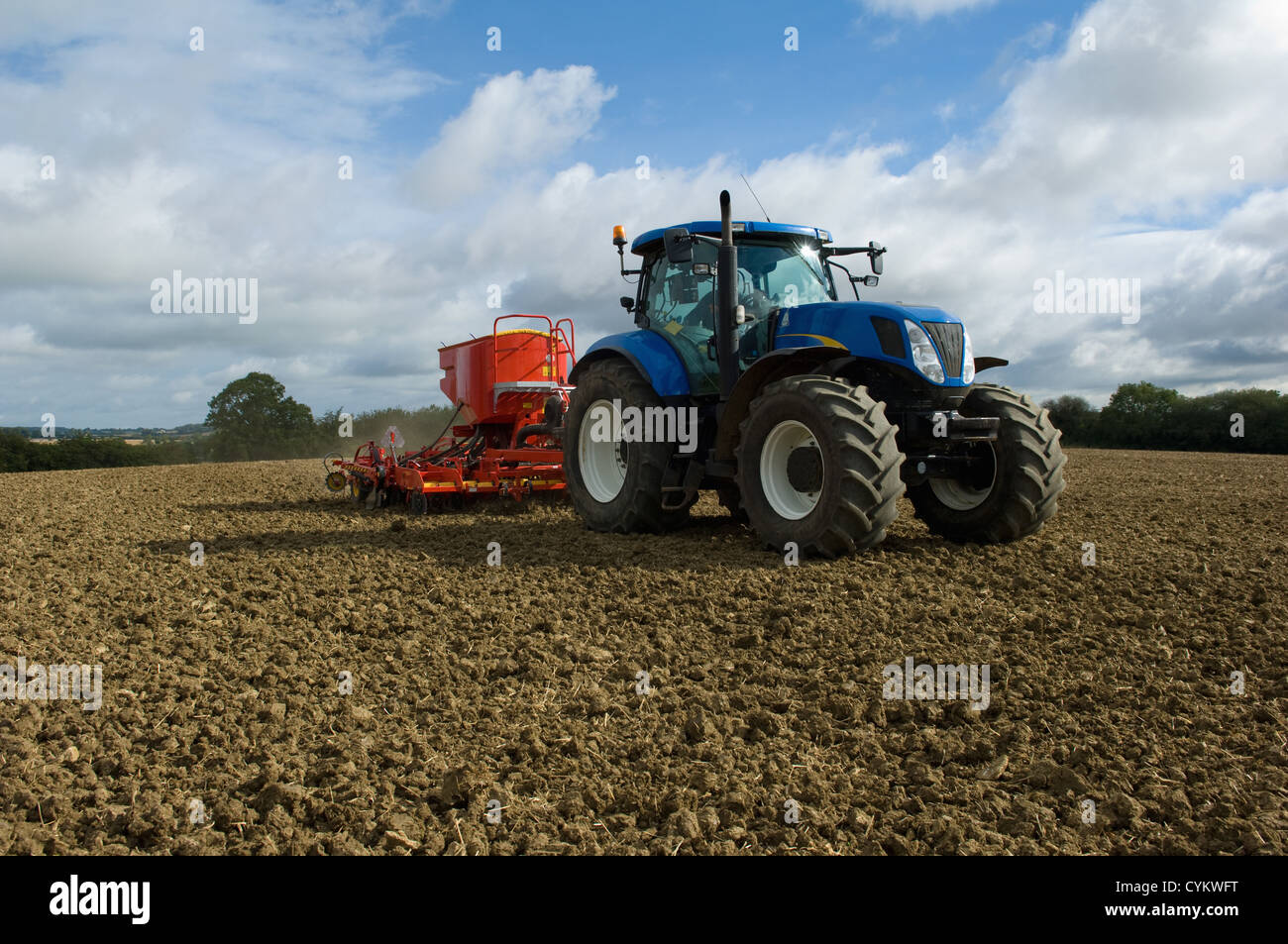 Tractor working in crop field Stock Photo - Alamy