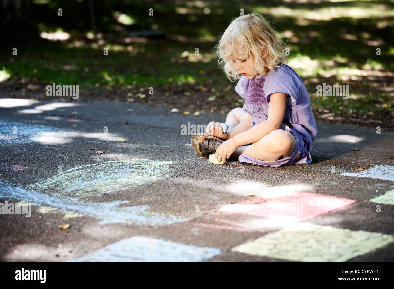 Girl drawing with sidewalk chalk Stock Photo - Alamy