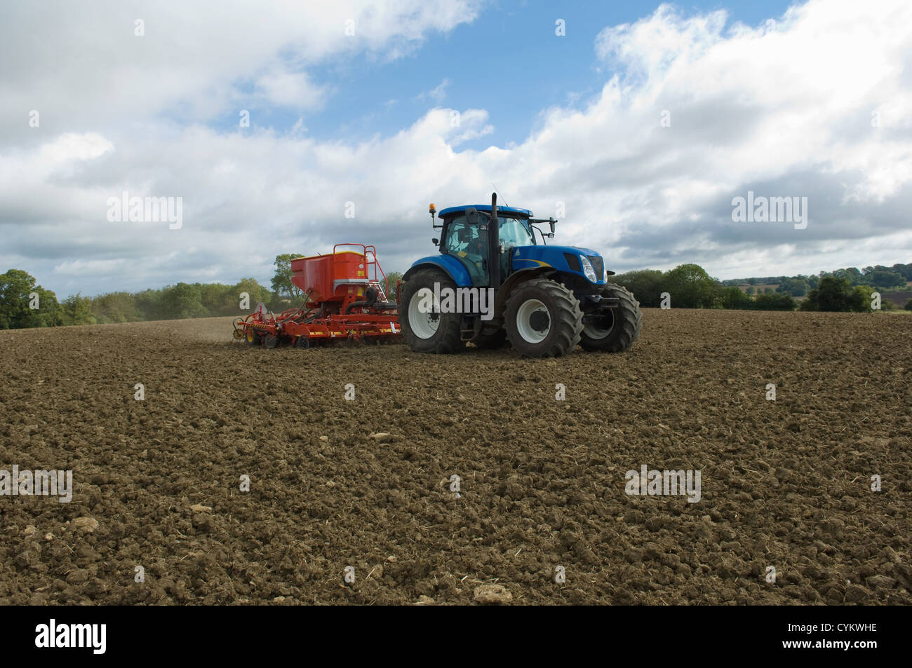 Tractor working in crop field Stock Photo - Alamy