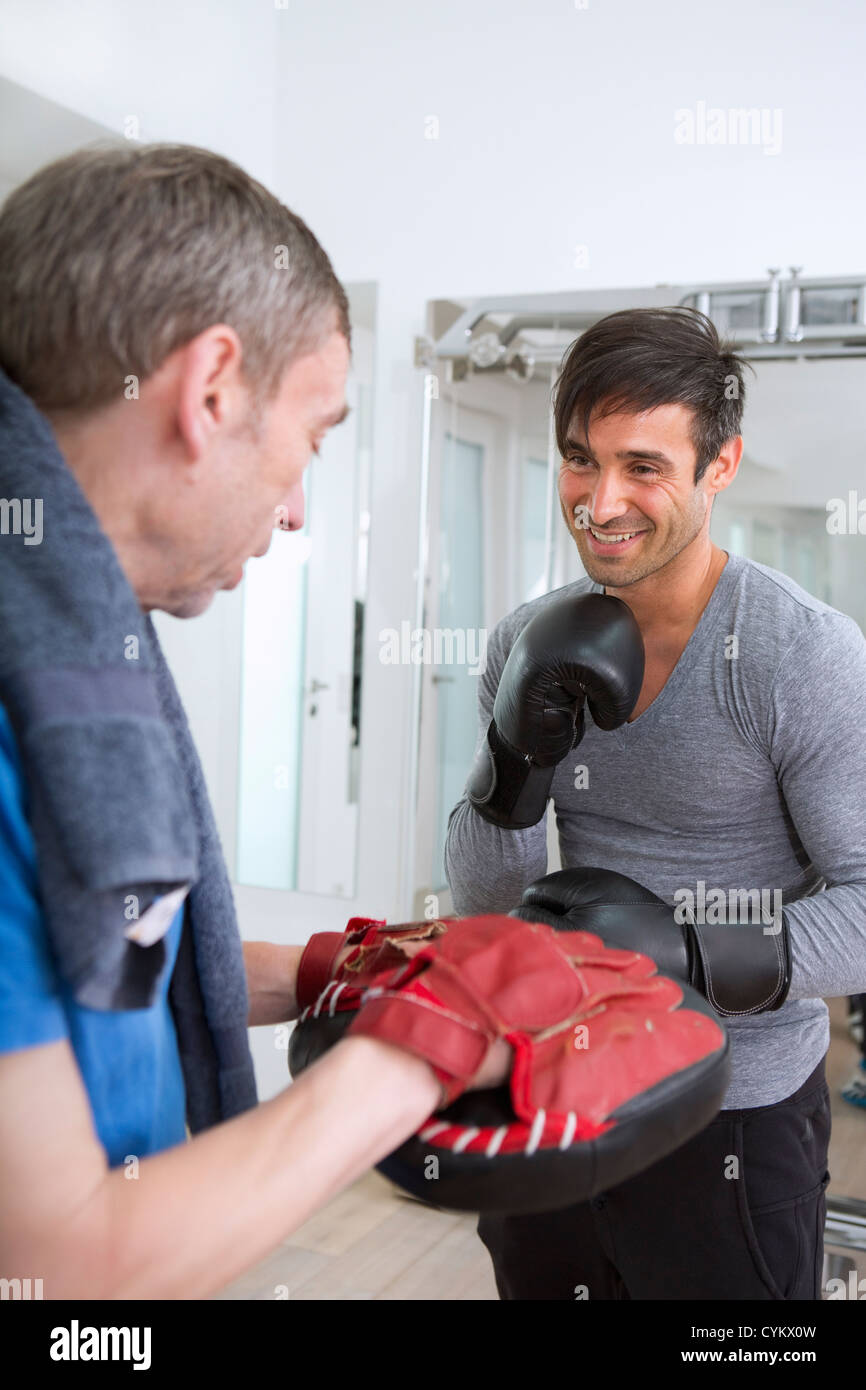Boxer practicing with trainer in gym Stock Photo - Alamy