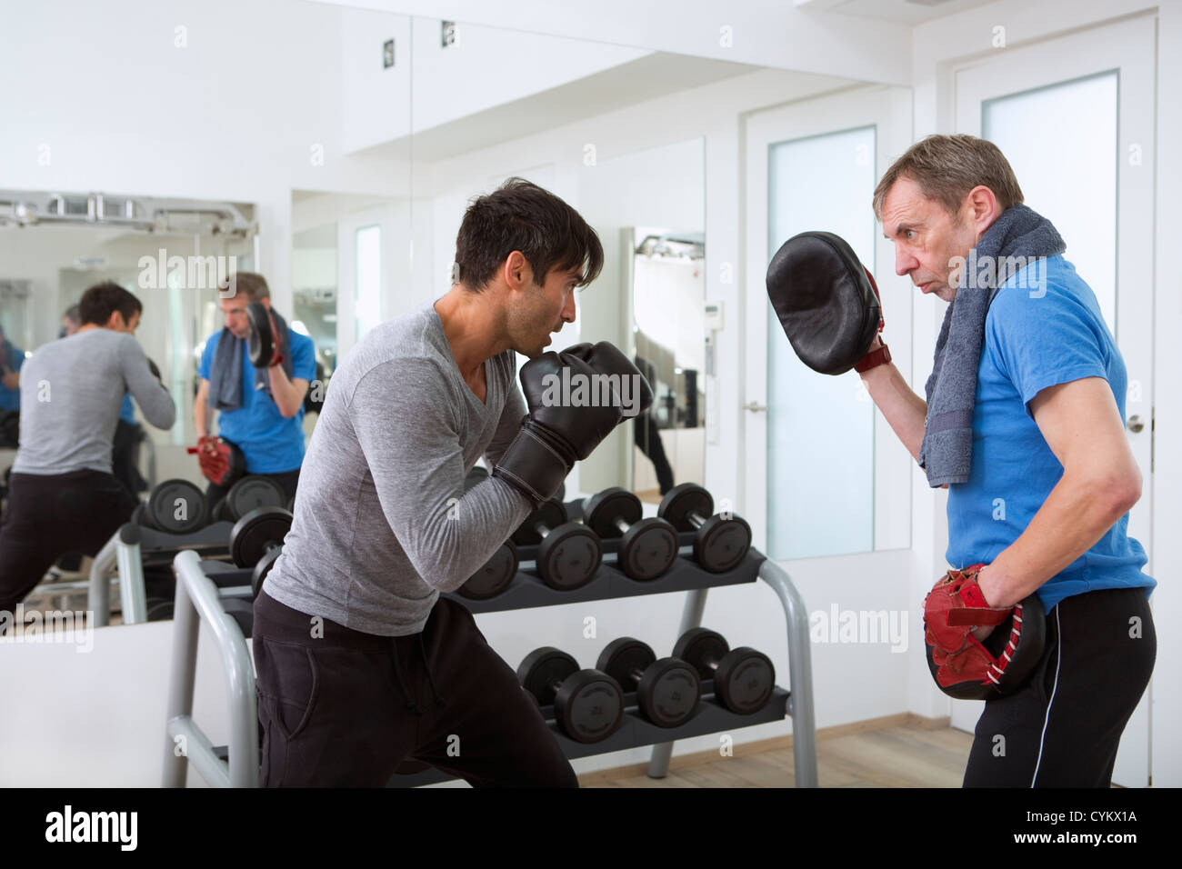 Boxer practicing with trainer in gym Stock Photo - Alamy