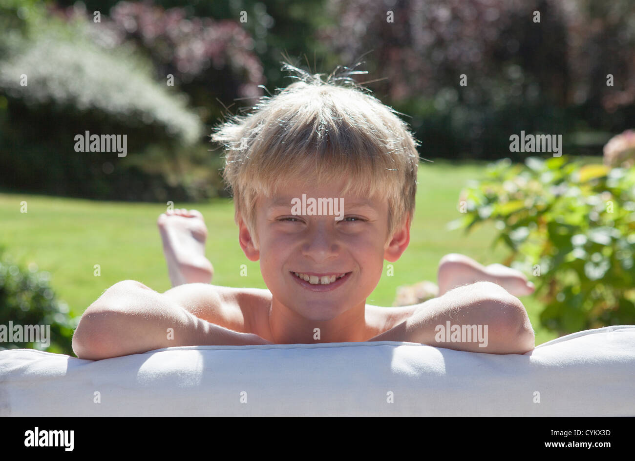 Smiling boy laying on sofa outdoors Stock Photo - Alamy