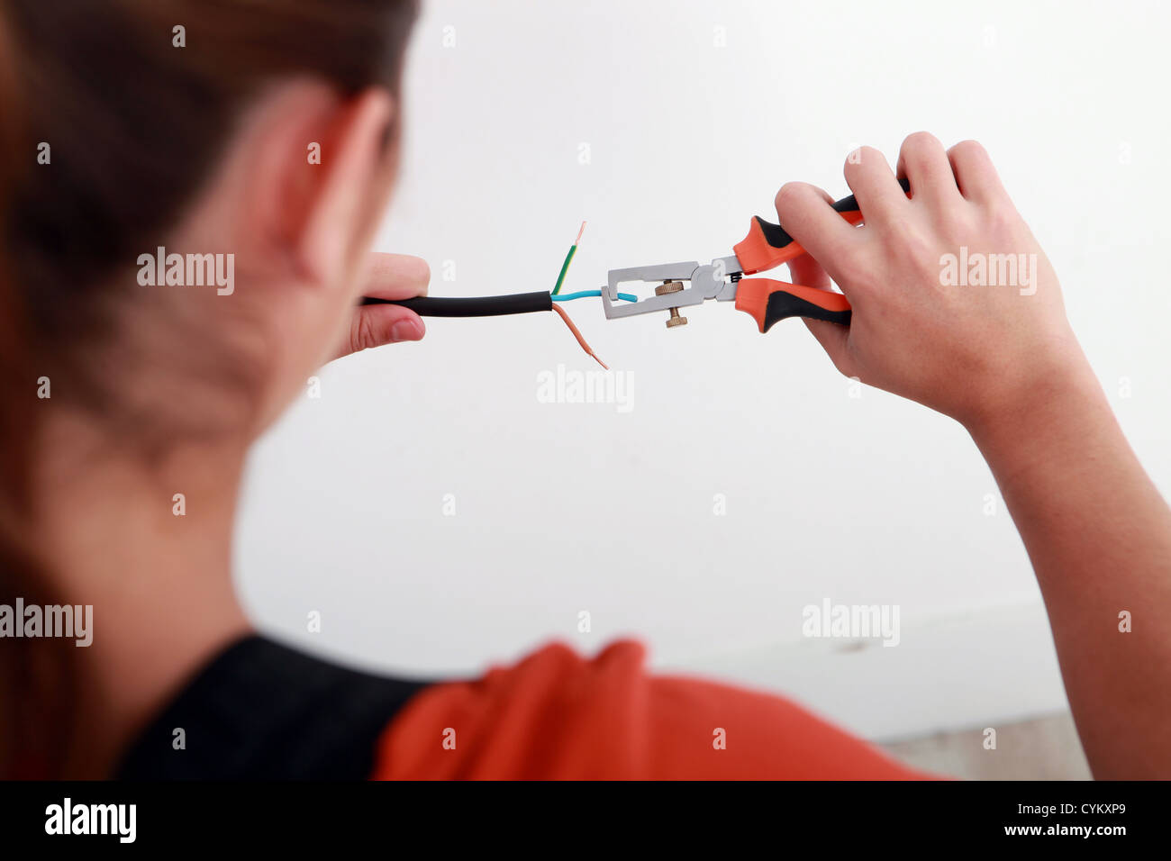 A female electrician stripping a wire Stock Photo - Alamy