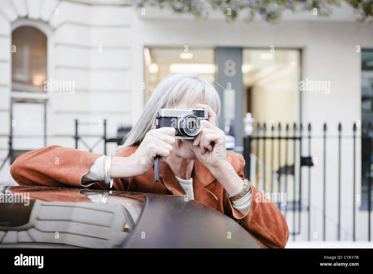 Woman taking picture on city street Stock Photo - Alamy