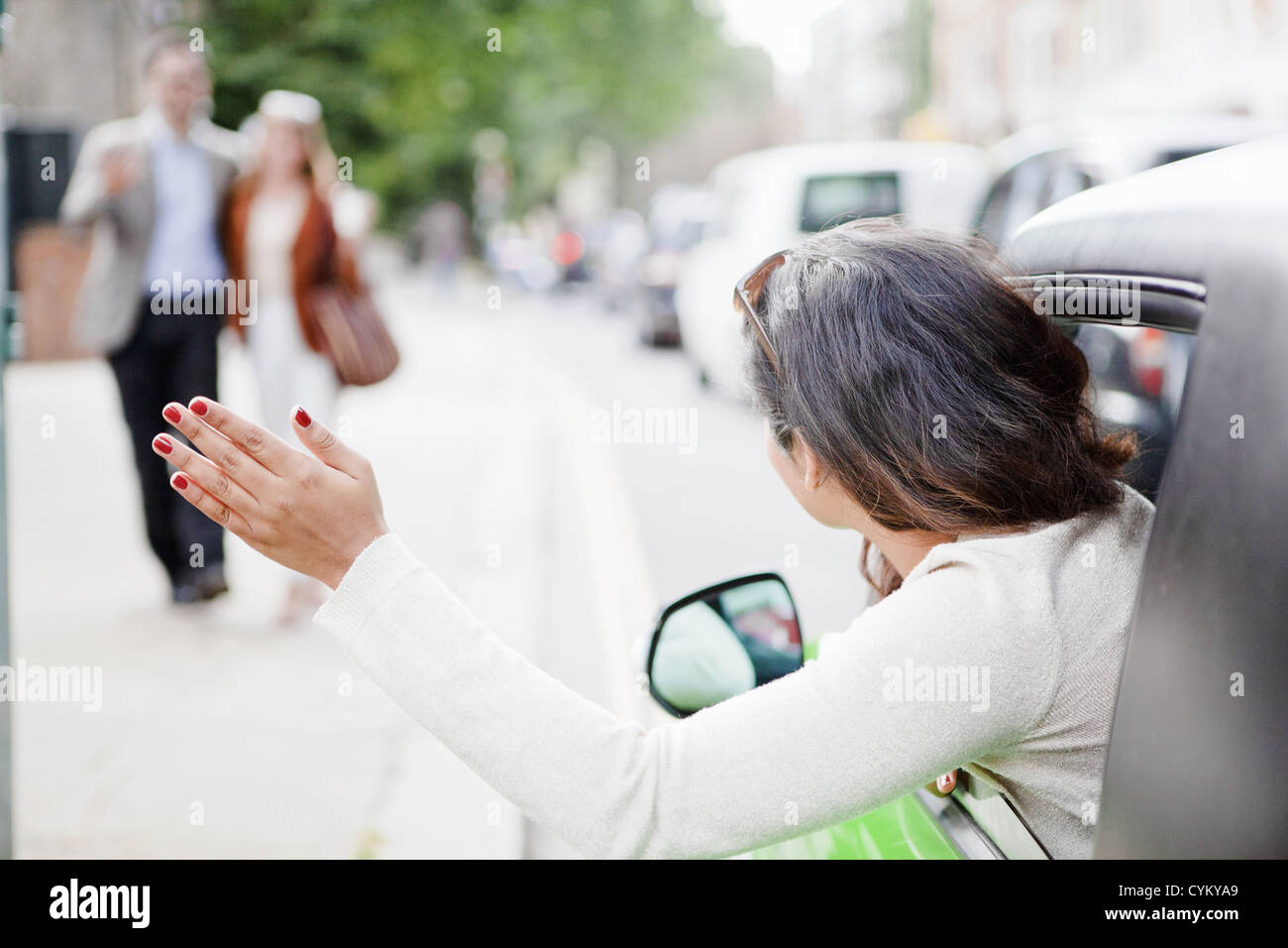 Woman hailing couple from car Stock Photo - Alamy