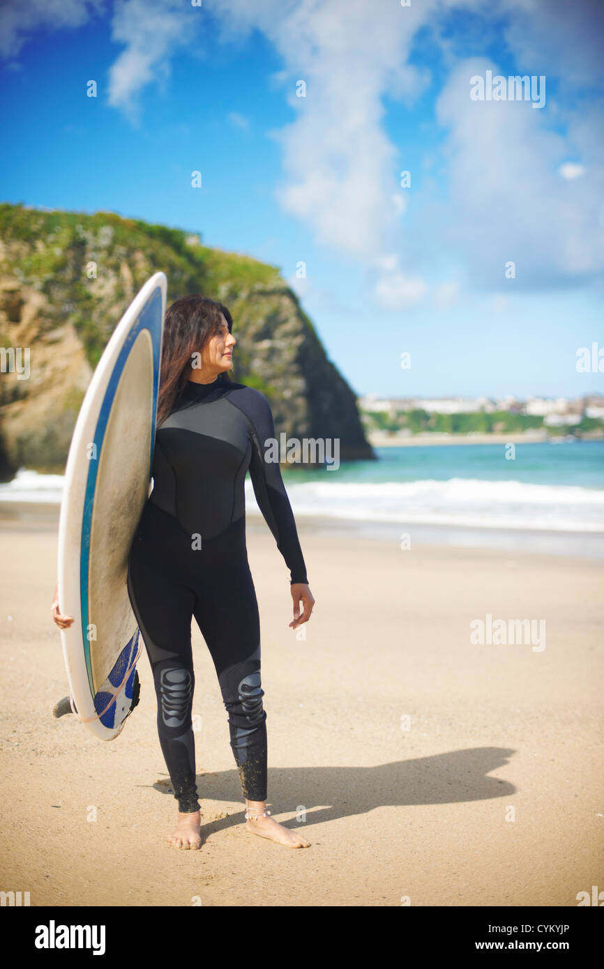 Surfer carrying board on beach Stock Photo - Alamy