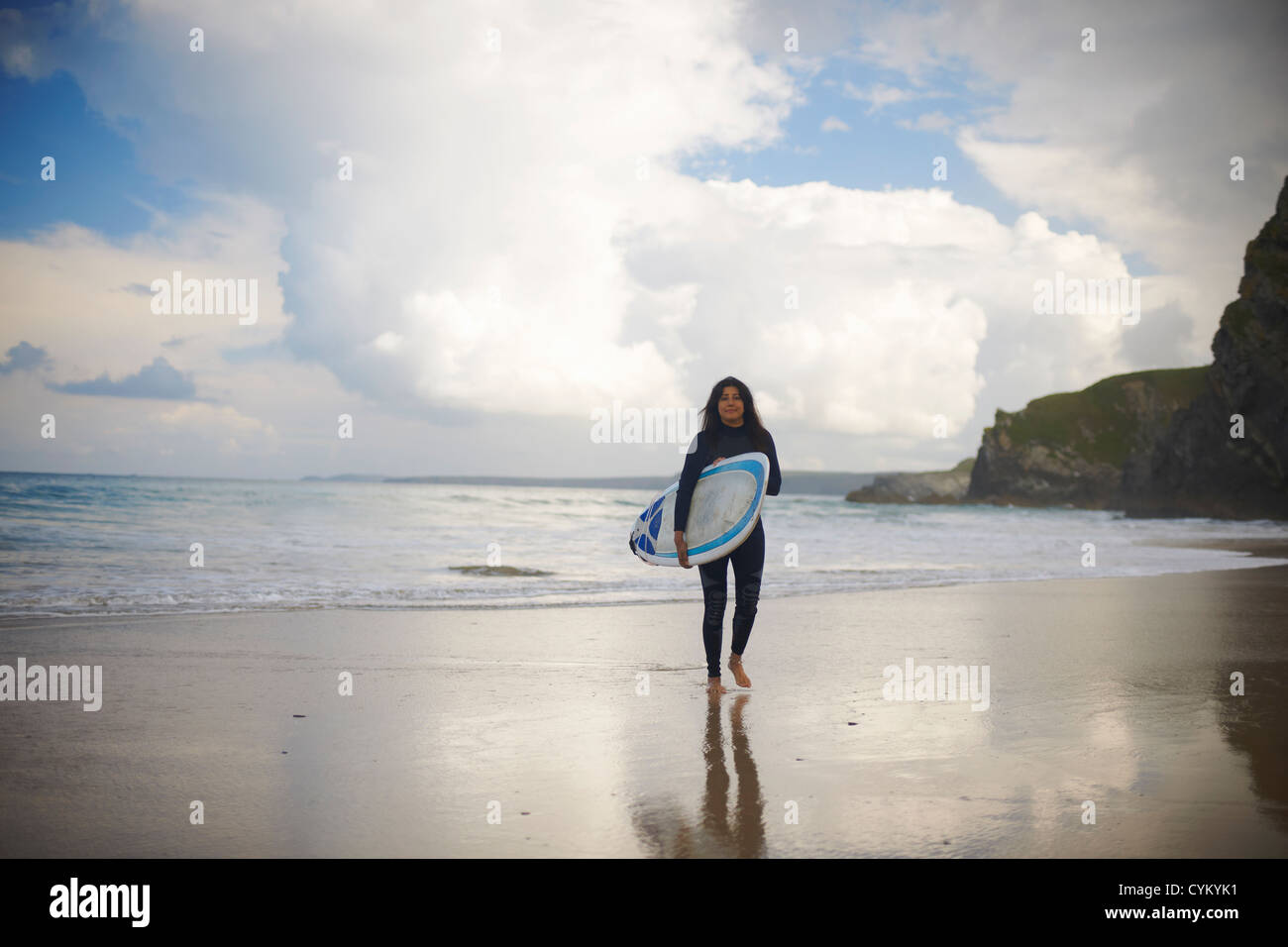 Surfer carrying board on beach Stock Photo - Alamy