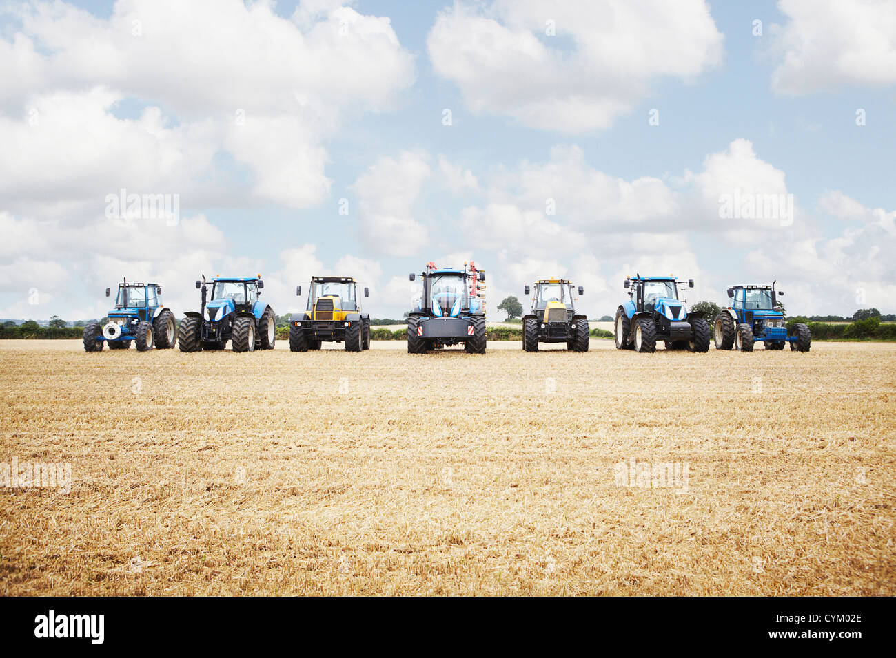 Tractor harvesting grains in crop field Stock Photo - Alamy