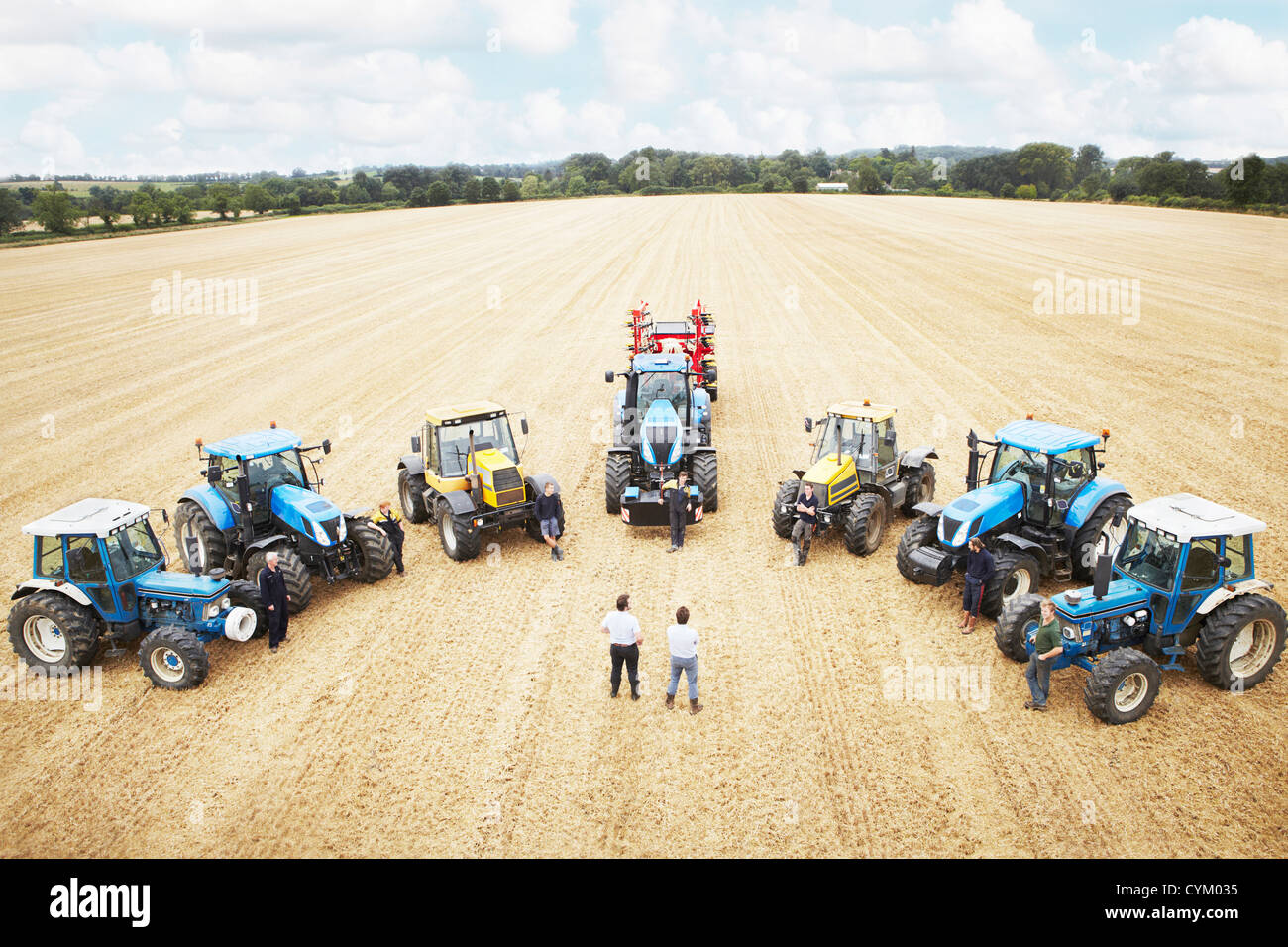 Farmers with tractors in crop field Stock Photo - Alamy