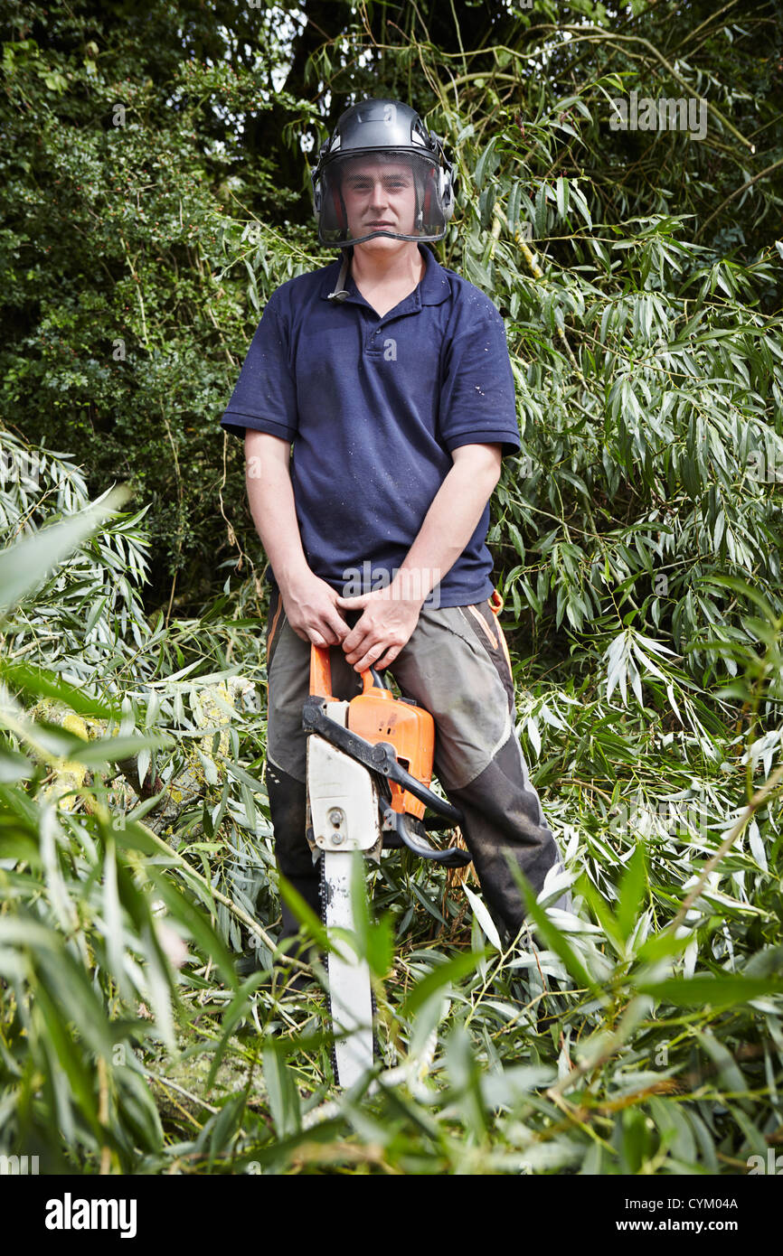 Worker holding chainsaw in forest Stock Photo - Alamy