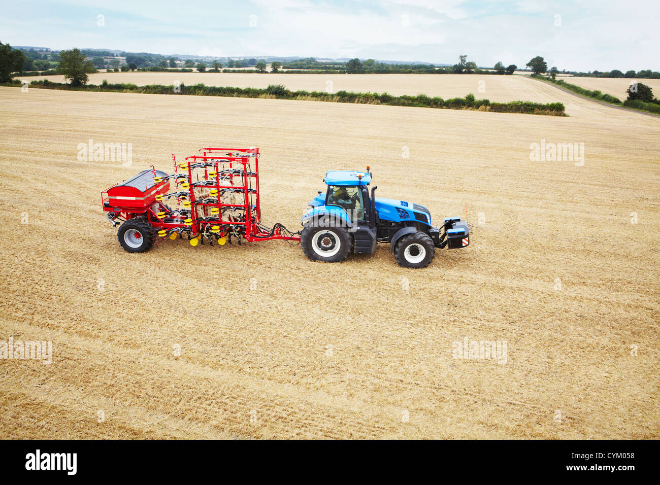 Tractor driving in tilled crop field Stock Photo - Alamy
