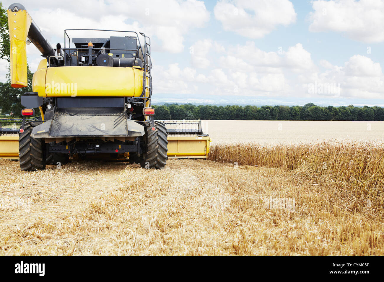 Harvester working in crop field Stock Photo - Alamy