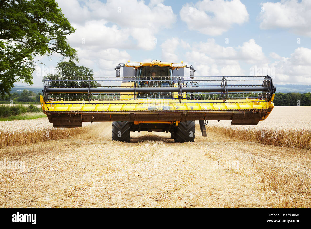 Harvester working in crop field Stock Photo - Alamy