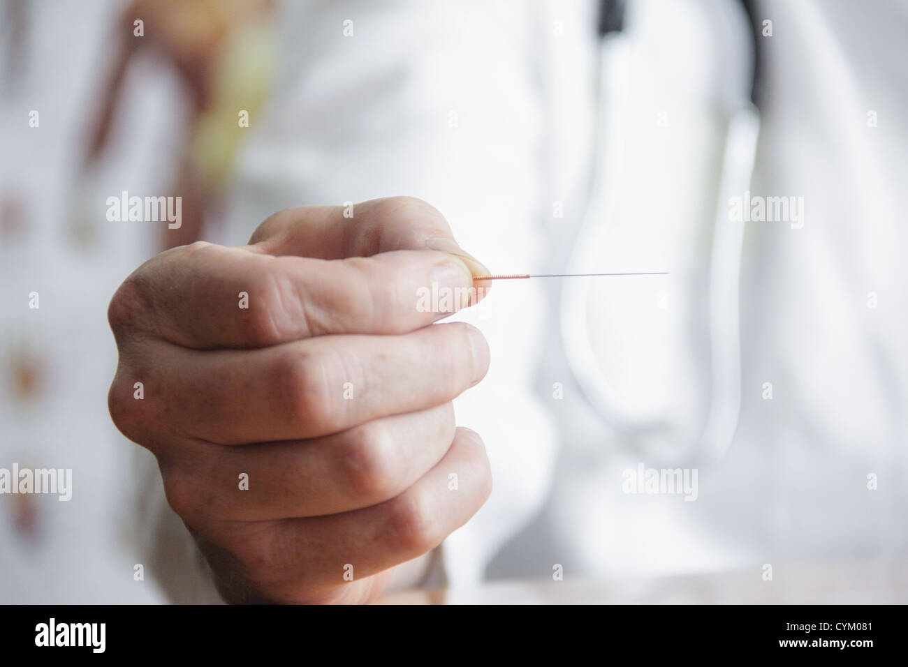 Close up of doctor holding needle Stock Photo - Alamy